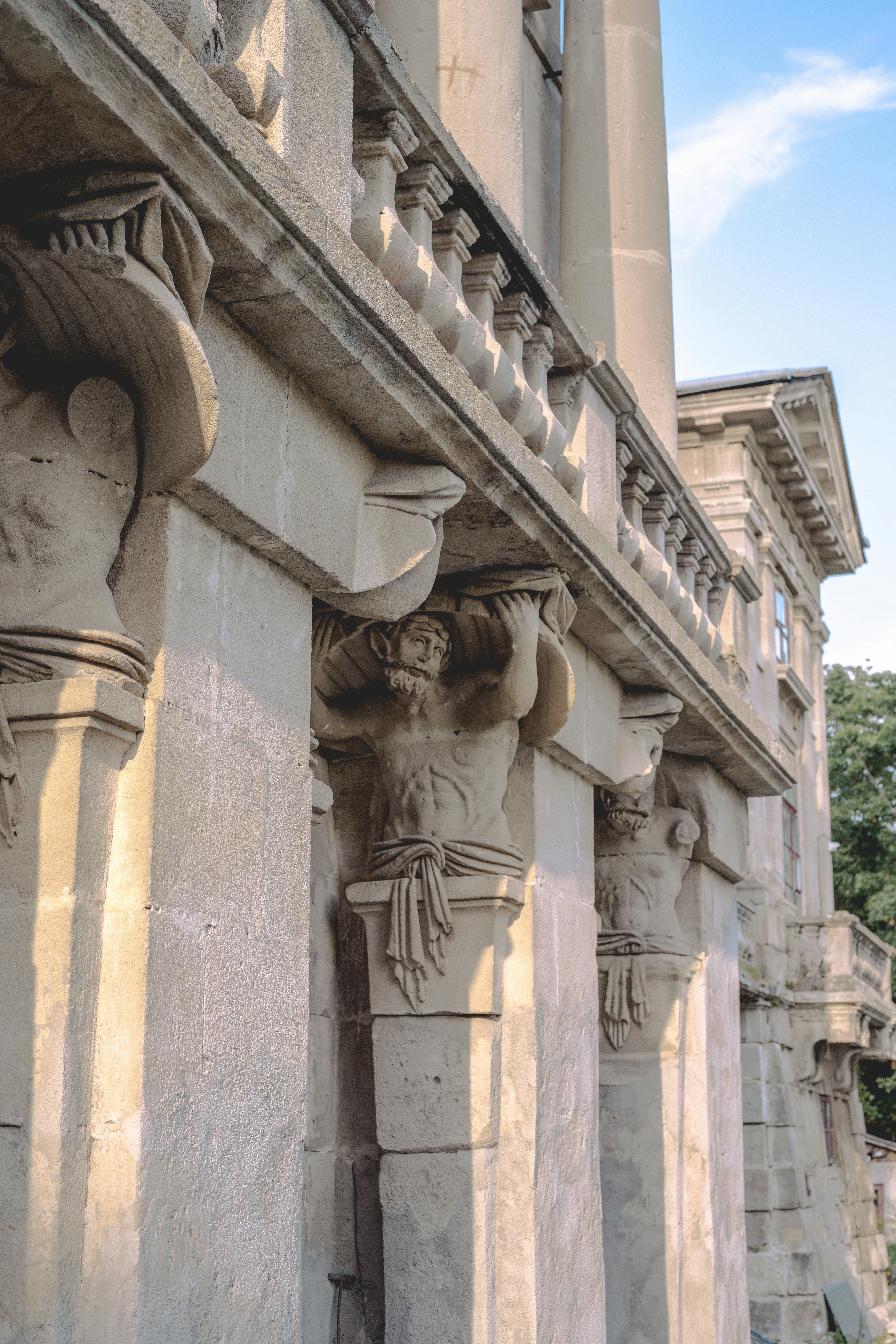 Stone Atlases: Carved Guardians support a sunlit arcade