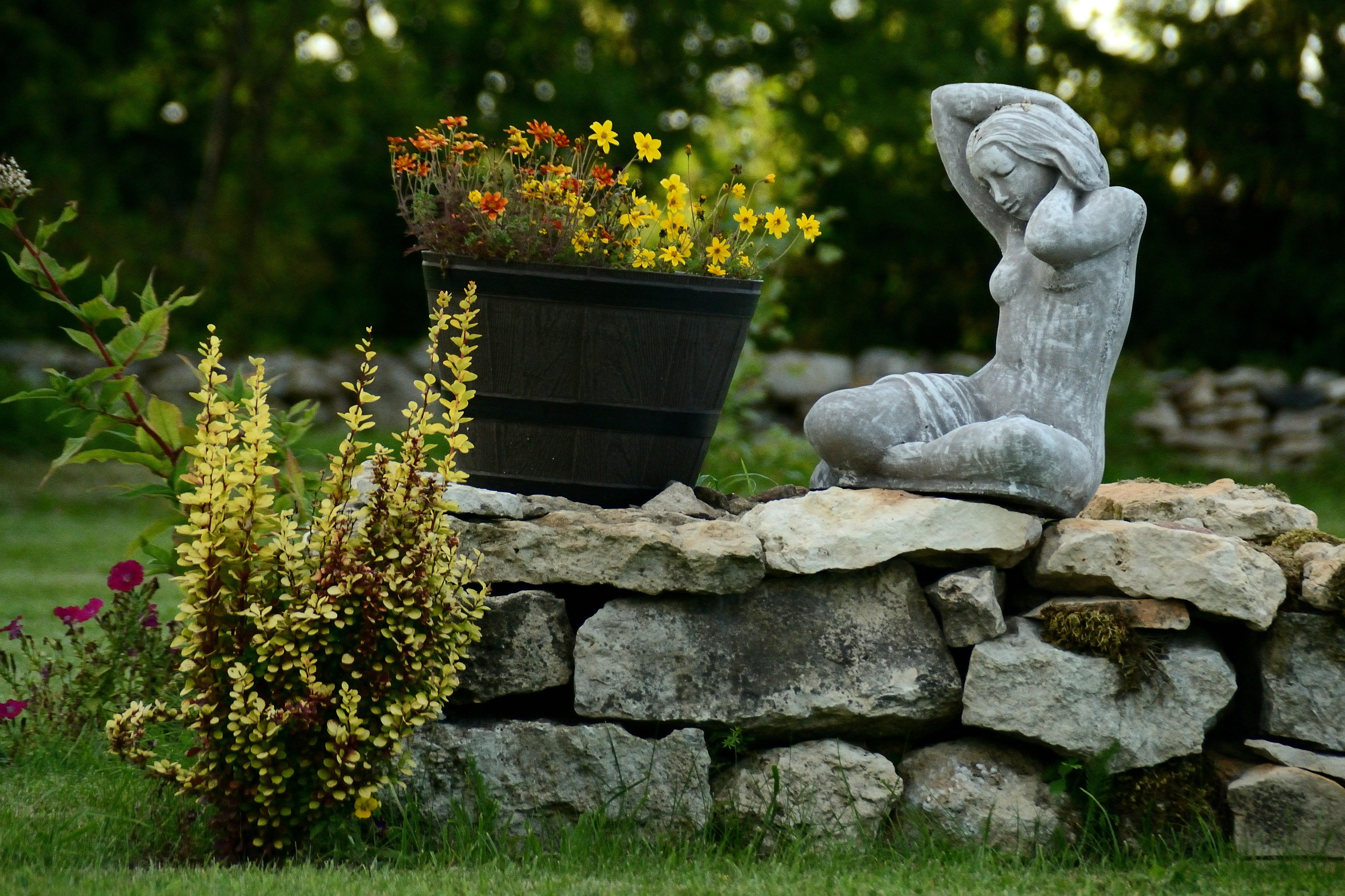 Stone Garden Sculpture and Blooming Pot on a Rustic Terrace