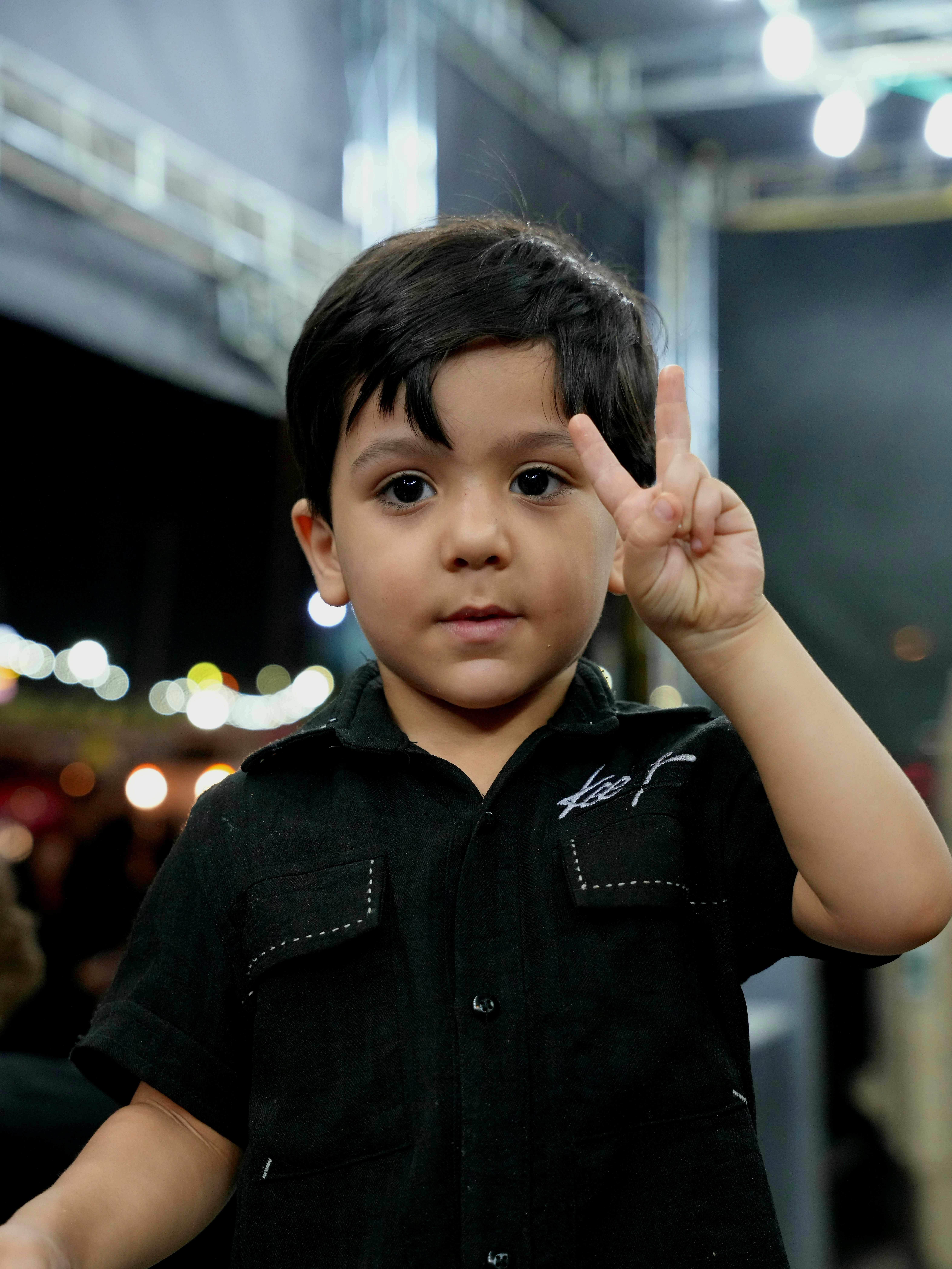 Peaceful Protest of a Young Smile: The Kid Holding Up a Peace Sign