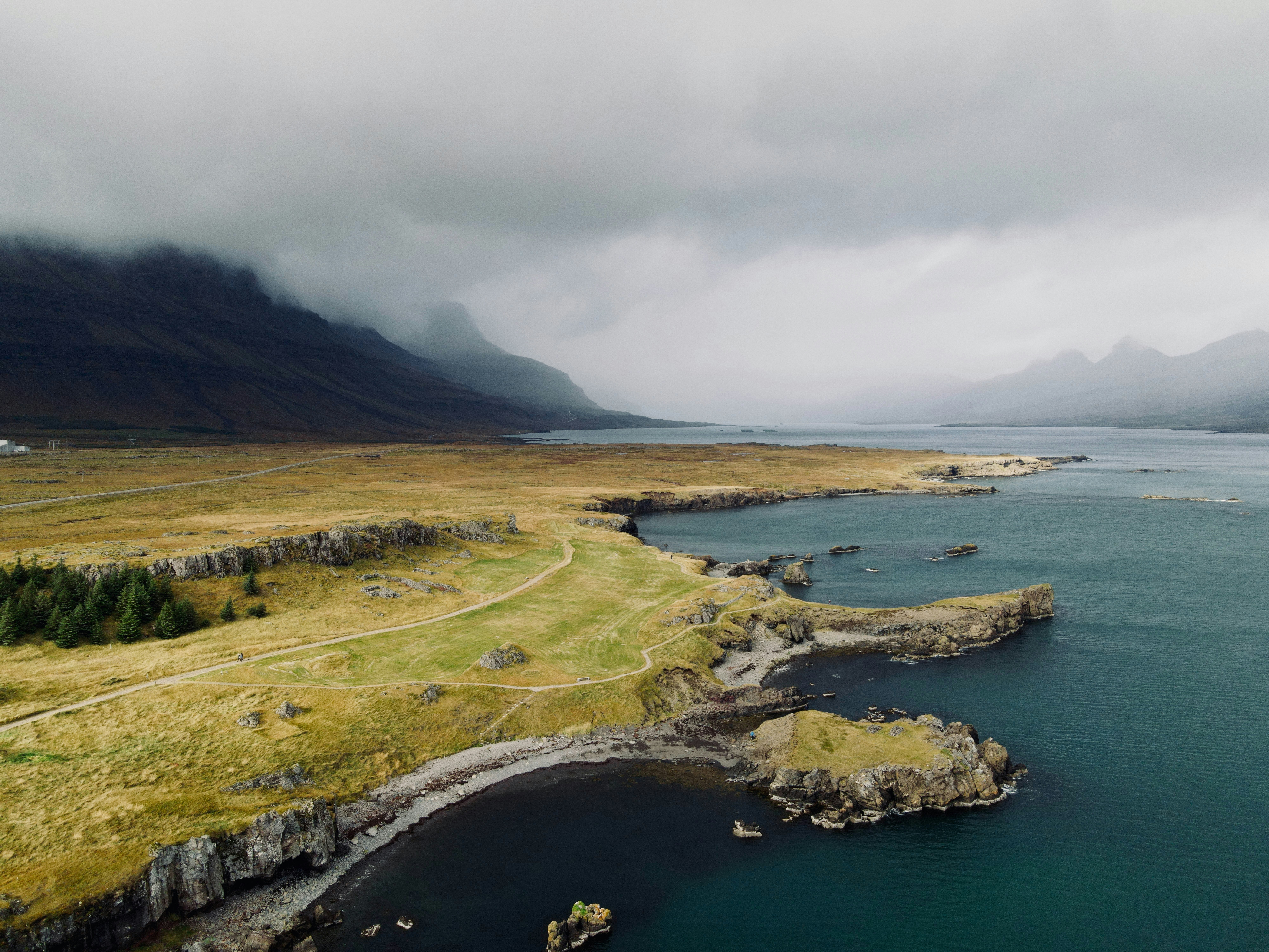 Coastal Fjord Plains Beneath Misty Peaks