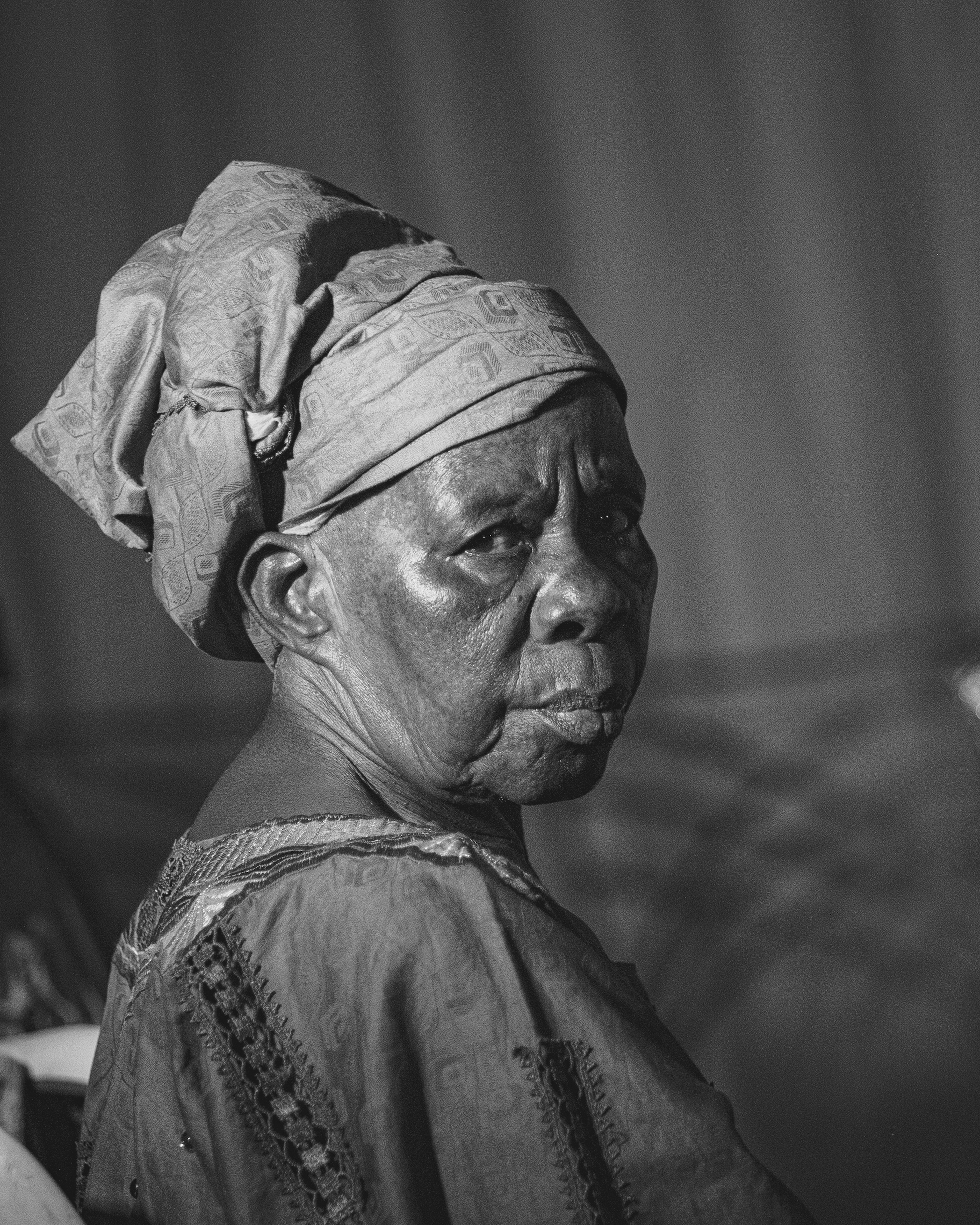 Portrait of Resolve: The Elderly Woman in a Wrapped Headscarf