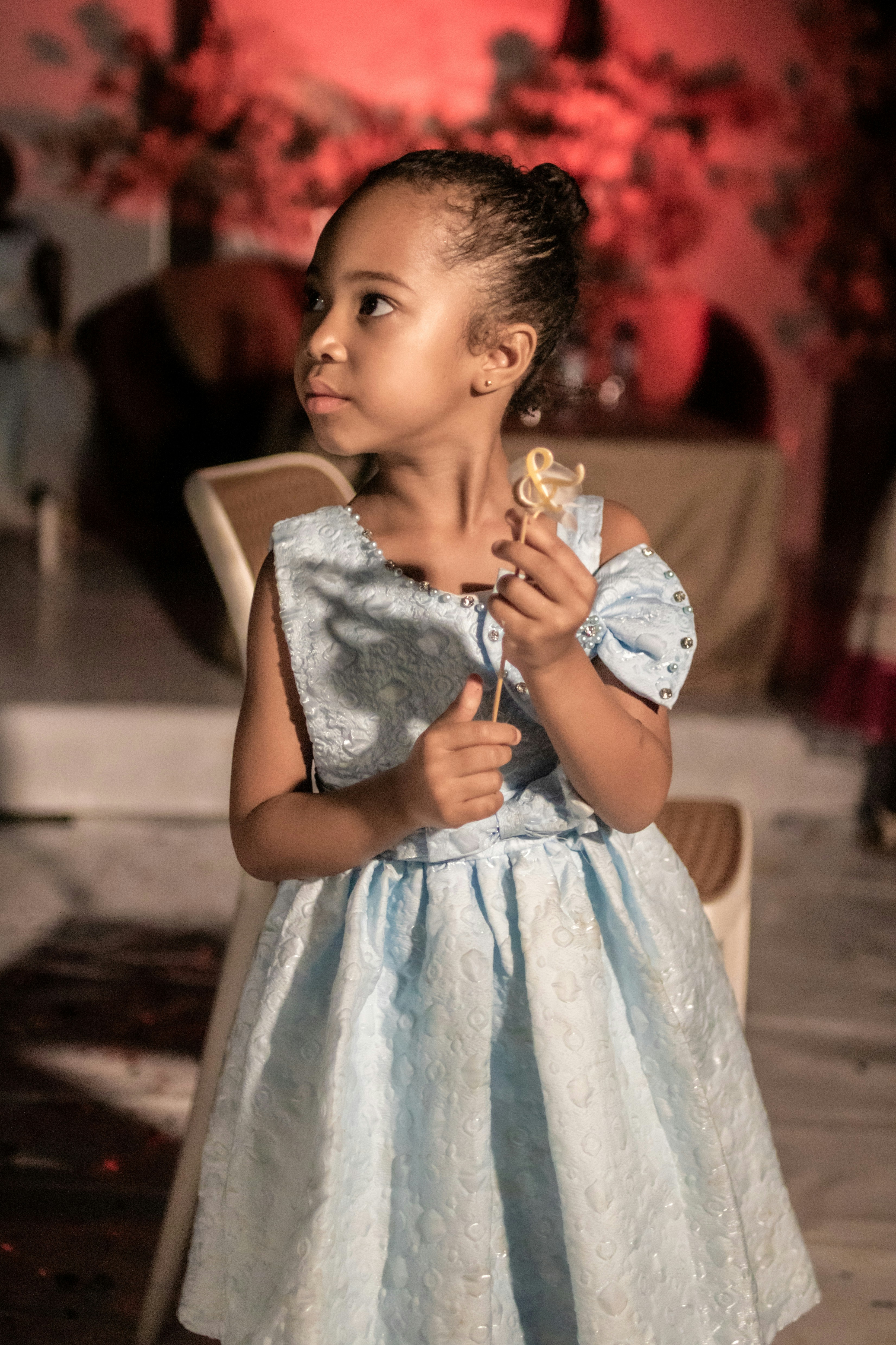A Moment of Wonder: Little Girl in a Powder Blue Dress Holds a Twist of Ribbon