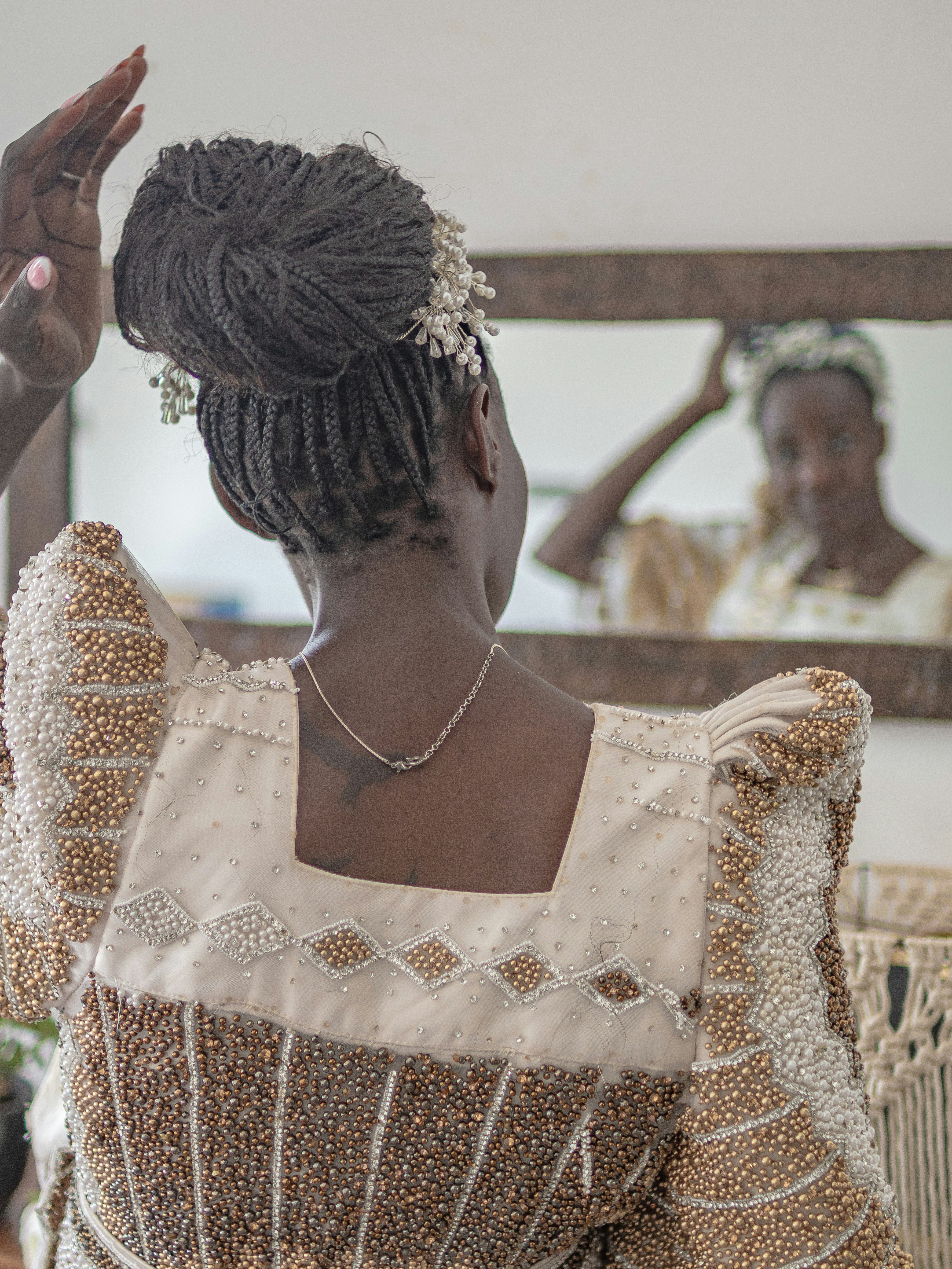 Backlit Grace: Ornate Beaded Dress in a Dressing Room Mirror