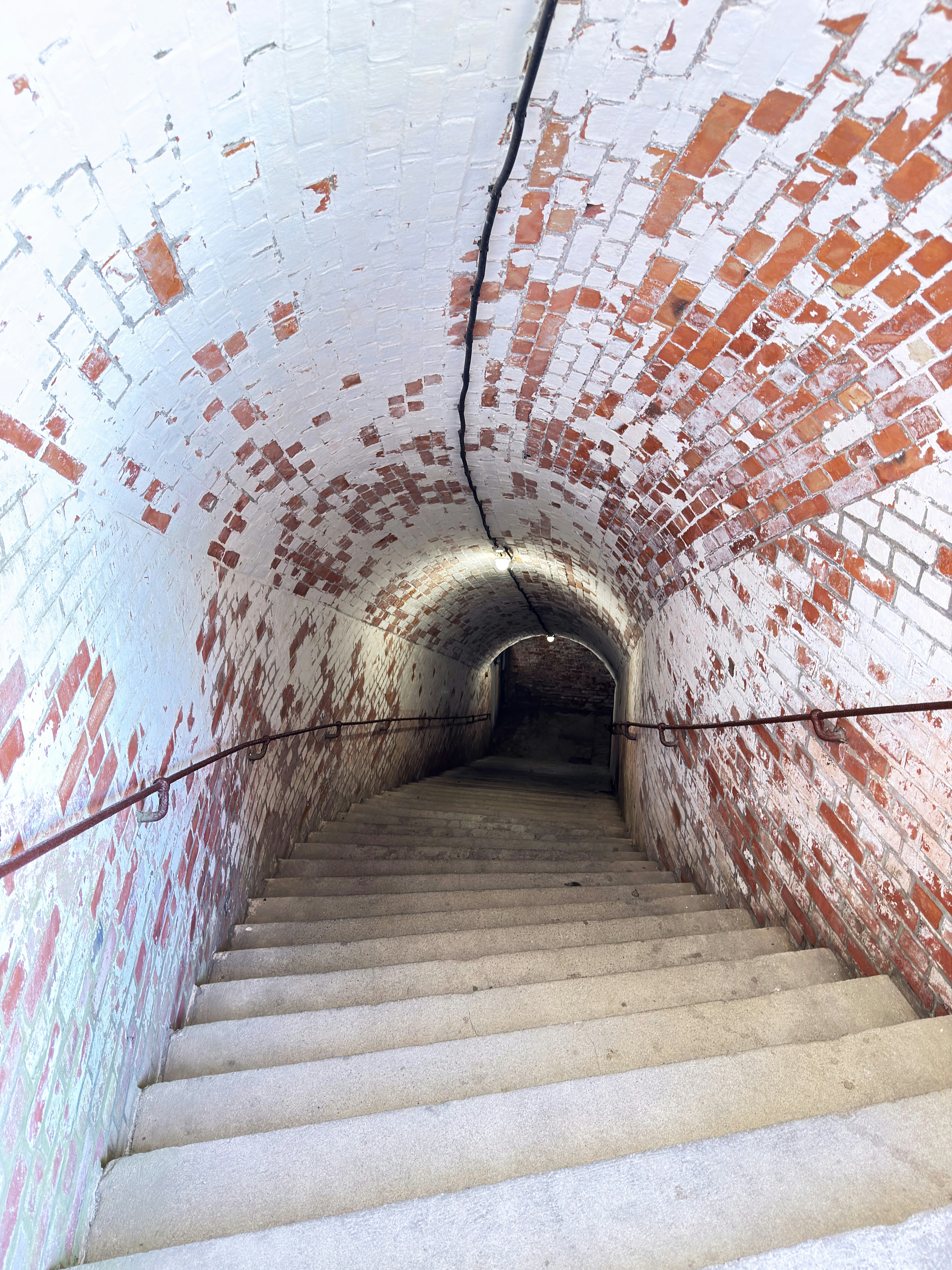 Brick Tunnel Descent: A Staircase Into Dim Light