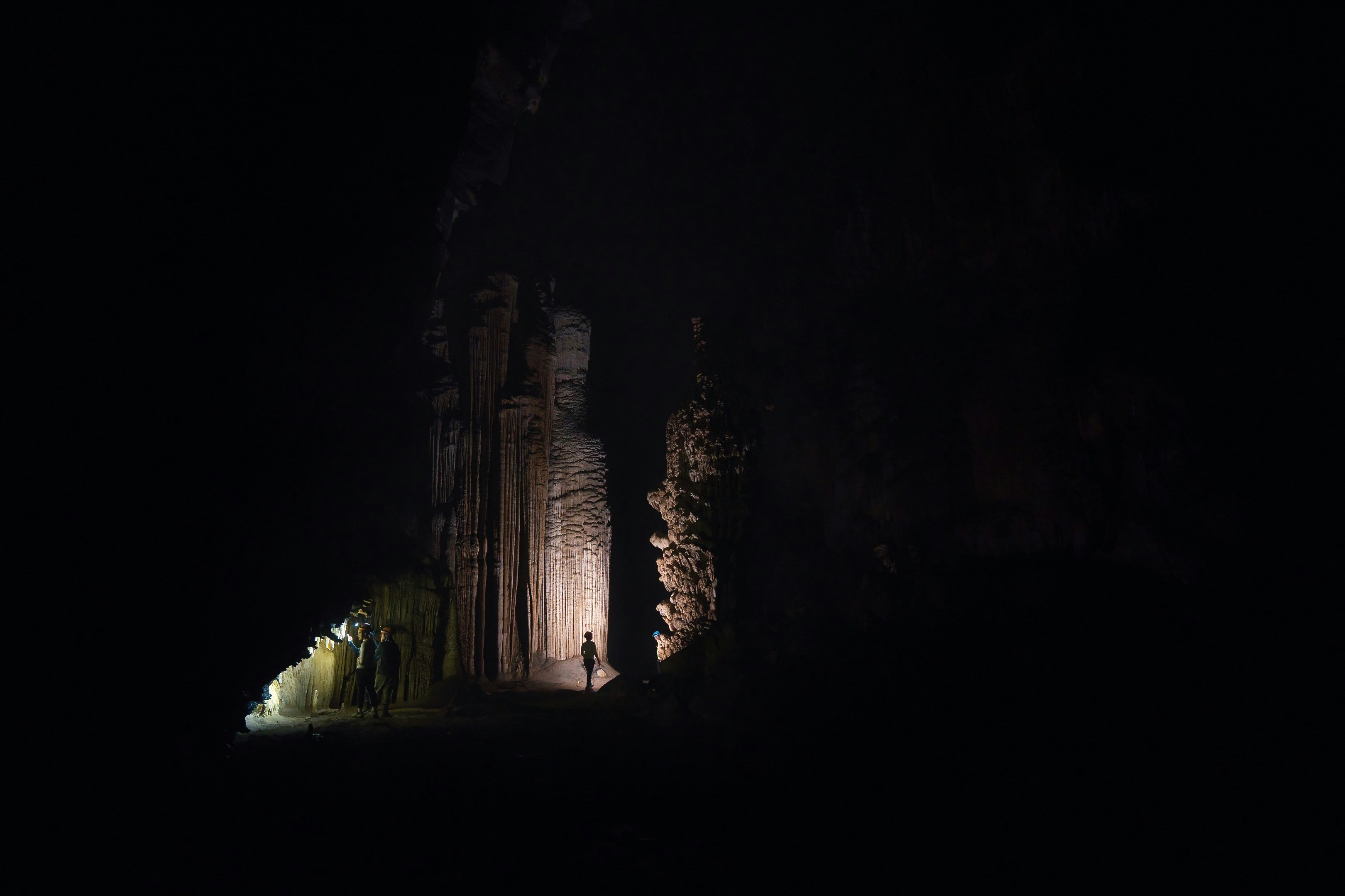Silent Column Corridor: Figures Illume a Hidden Chamber