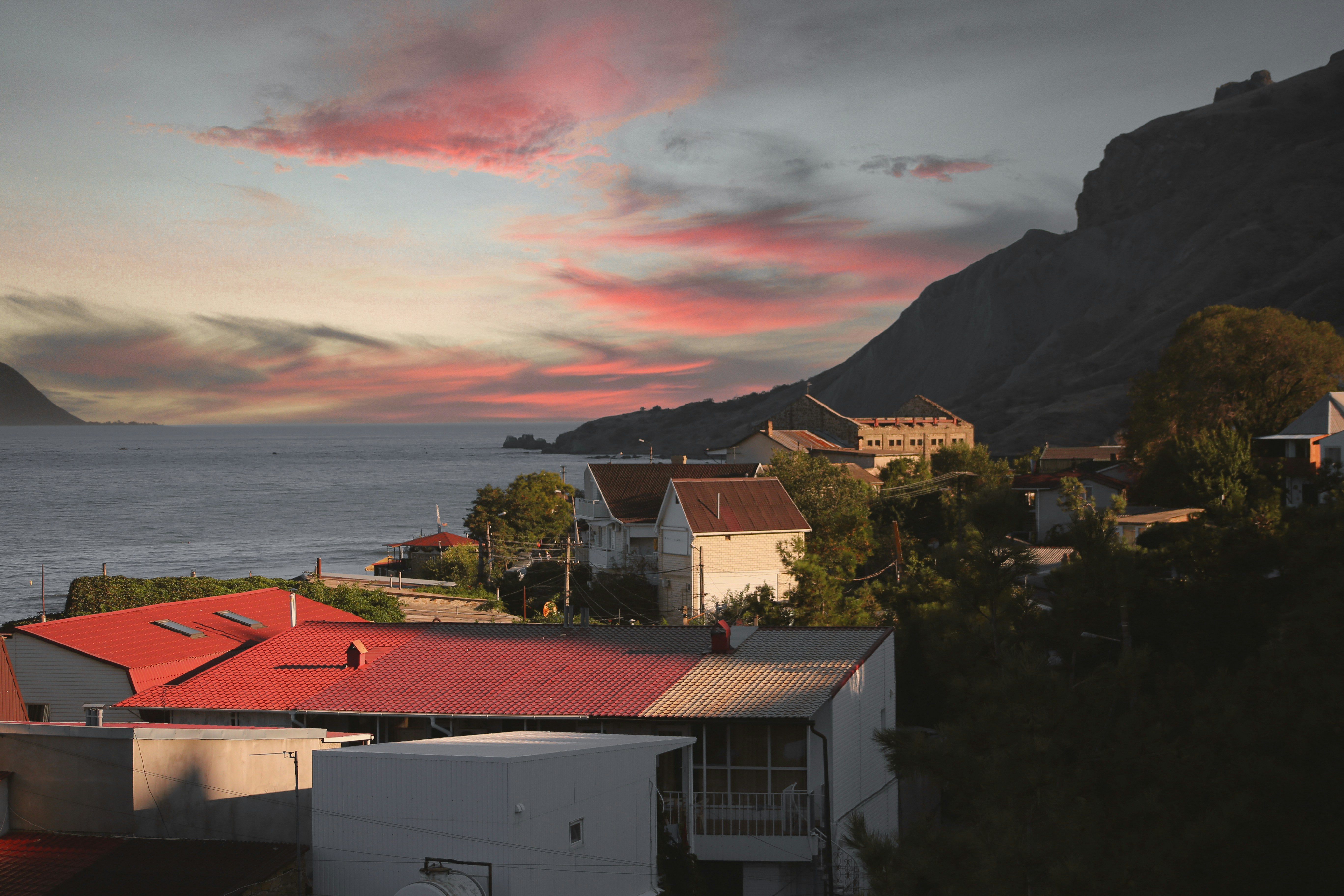 Sunset Over Village Rooftops with Mountain Backdrop