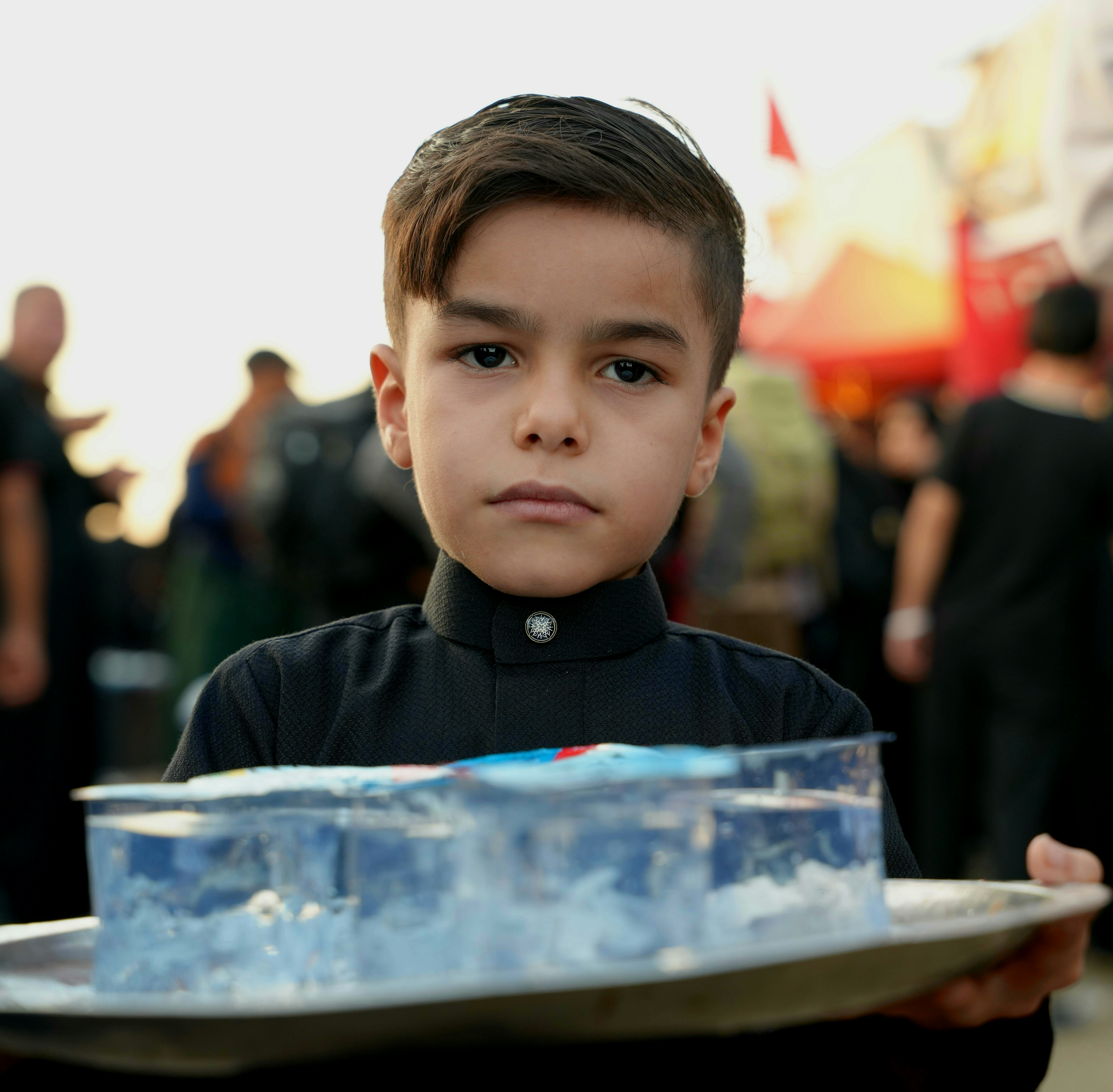 Under the Crowd: A Quiet Moment with a Child and a Gelatinous Edible Tray