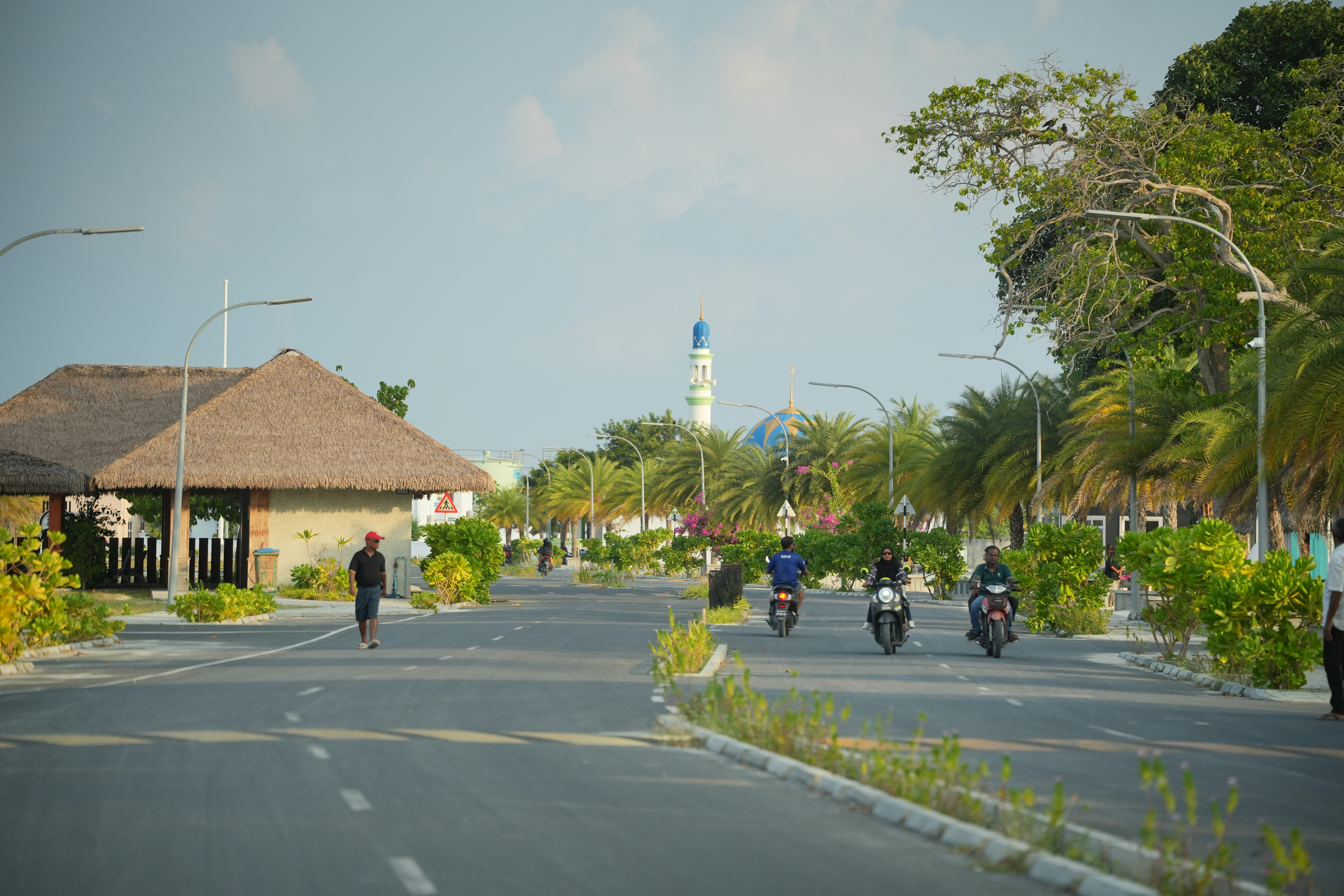 Sunlit Boulevard toward a distant blue-domed shrine