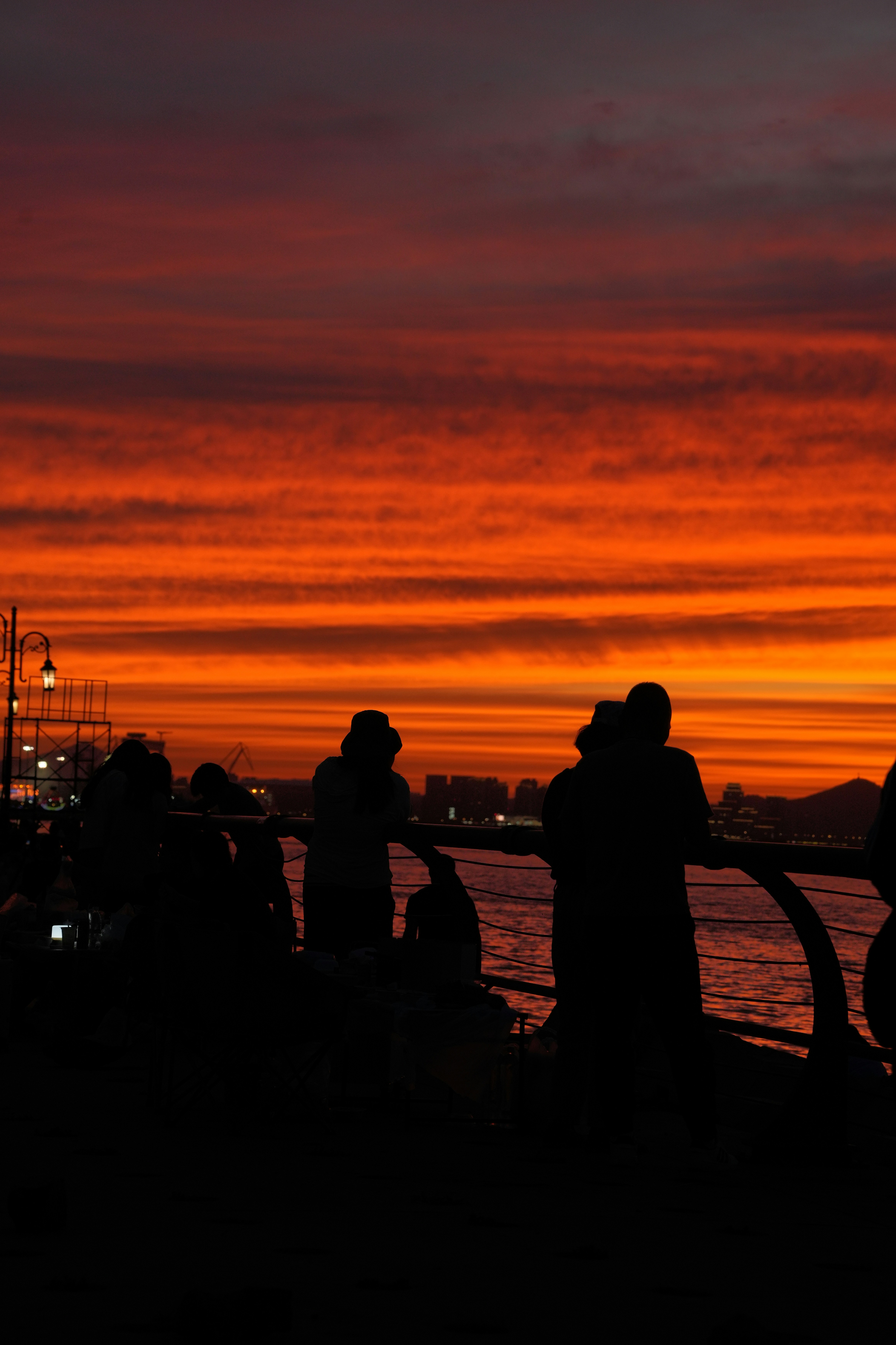 Silhouetted Lovers at Dusk Over a Glowing City Harbor