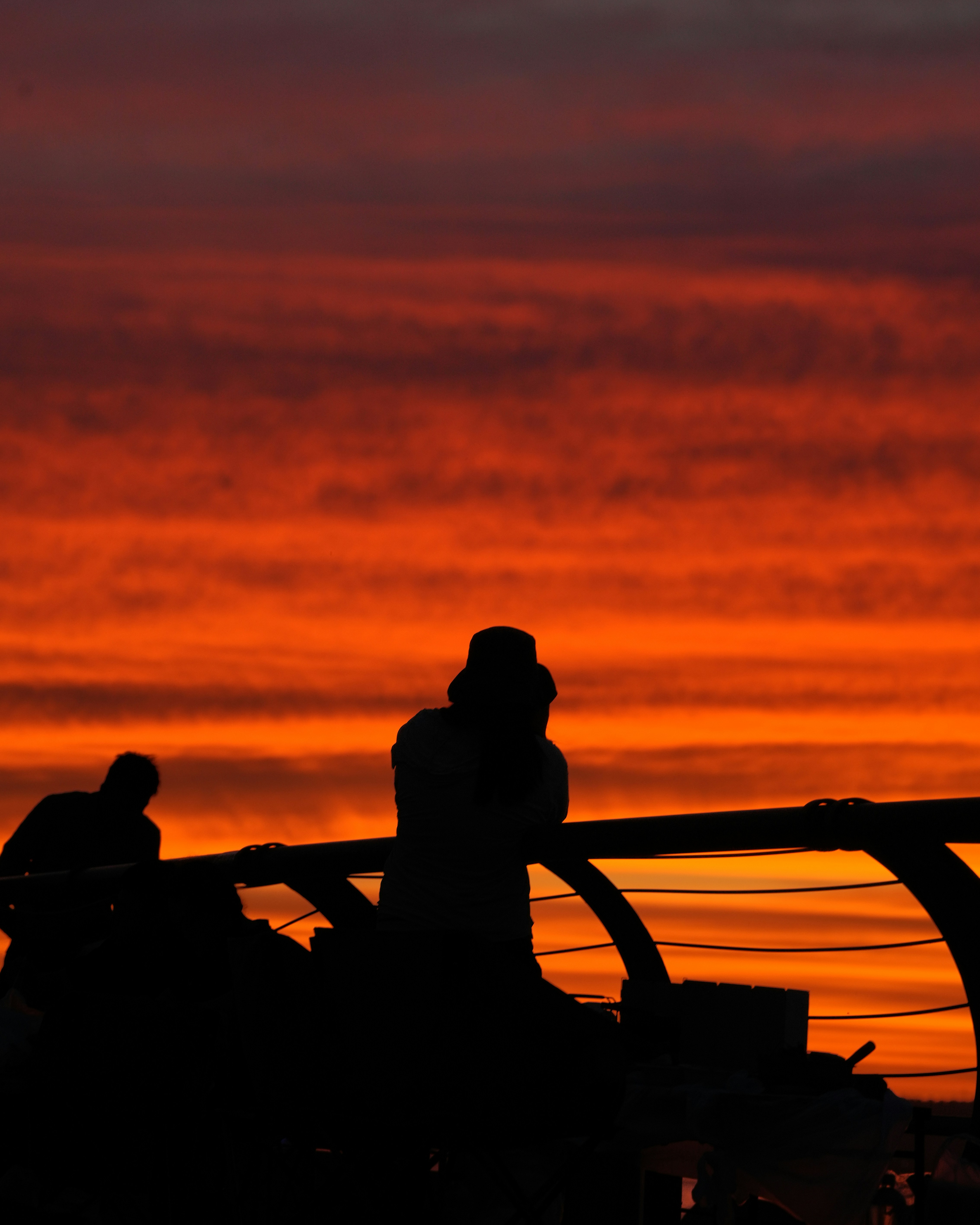 Silhouette at Dusk: Figures Against a Fiery Horizon