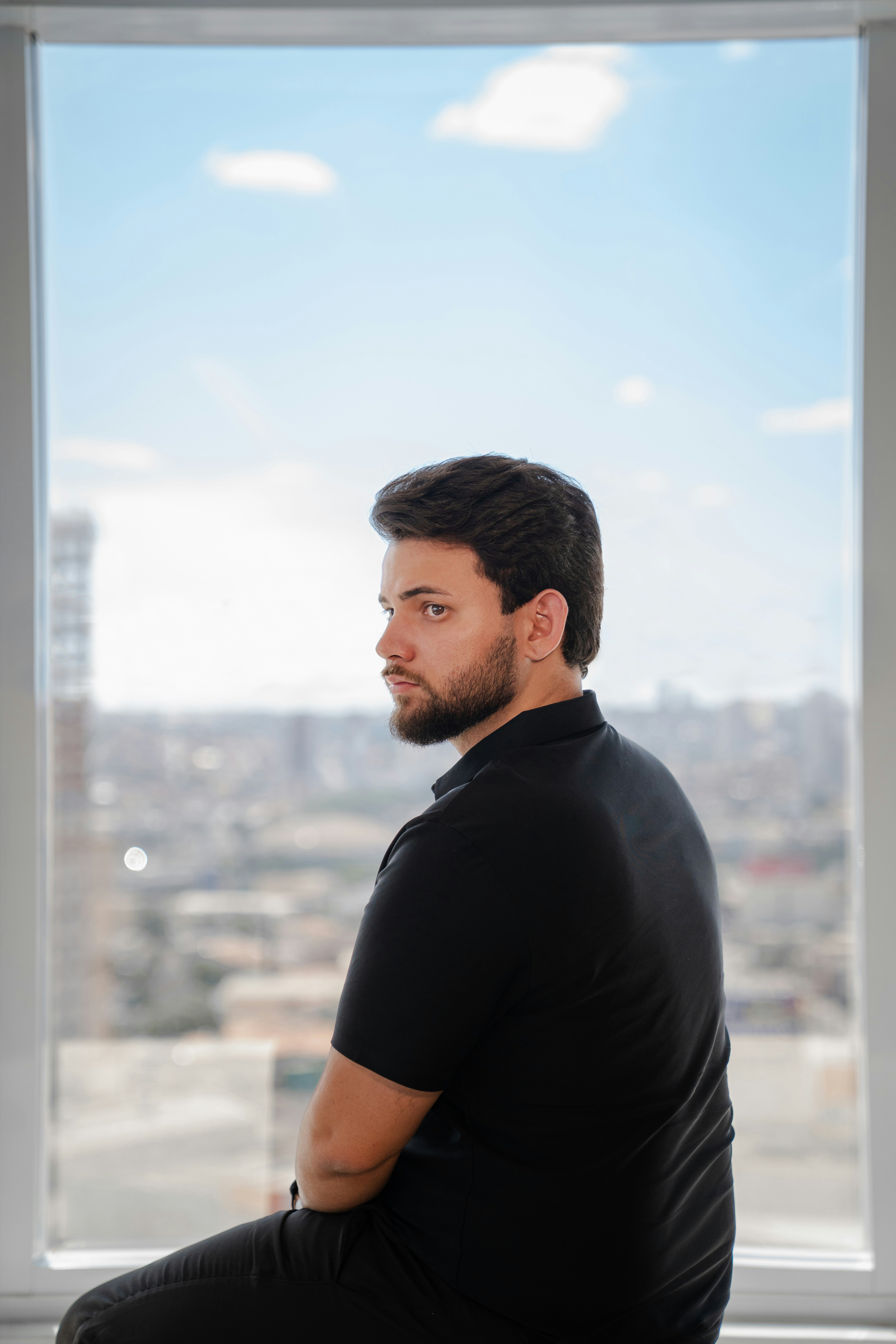 Portrait in Window Light: A Calm Gaze Against the City Horizon