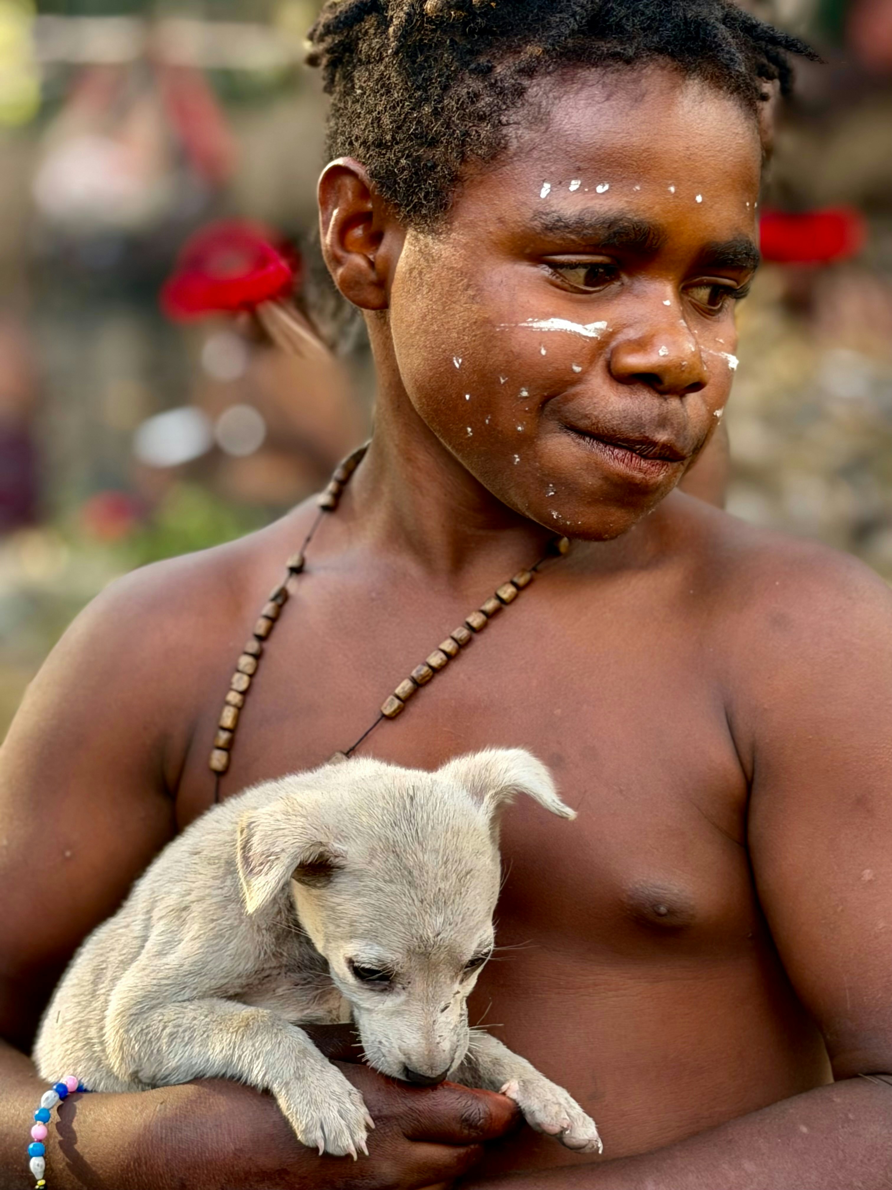 Child with a Gentle Hold: A Shared Moment with a Puppy