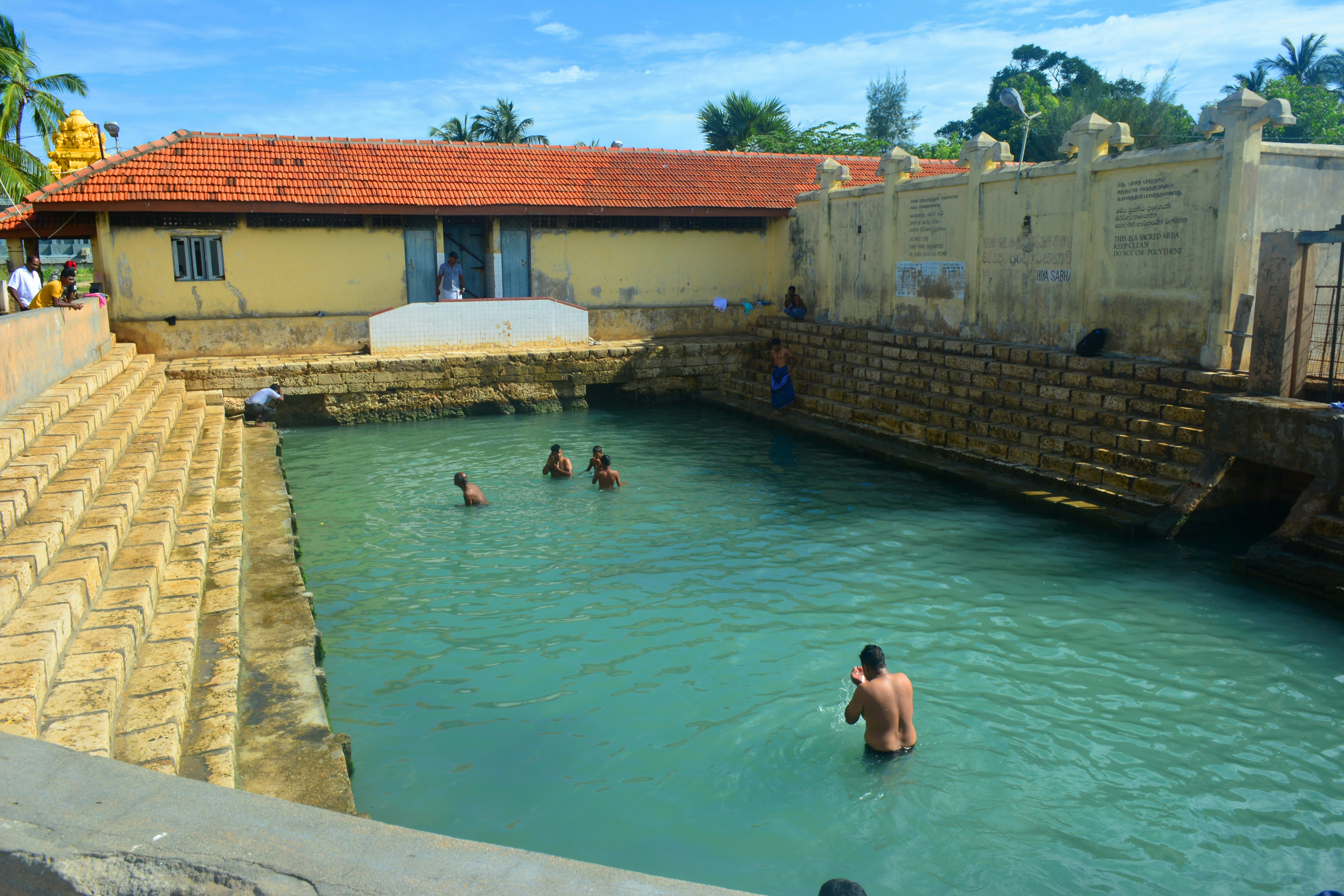 The Sacred Tank: Bathers and Temple Steps by Turquoise Waters