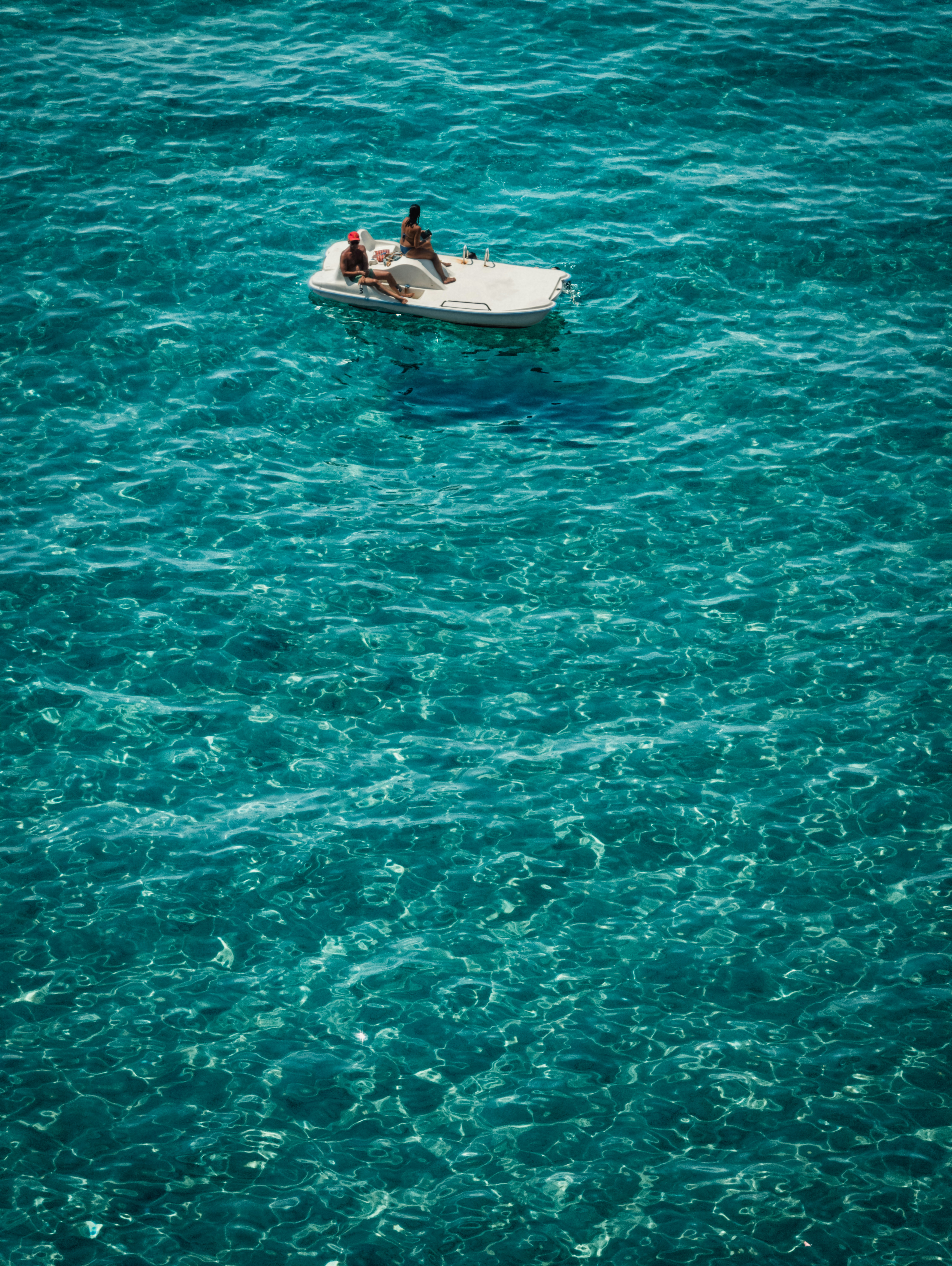 Tiny Boat, Vast Sea: A Quiet Moment on Turquoise Waters