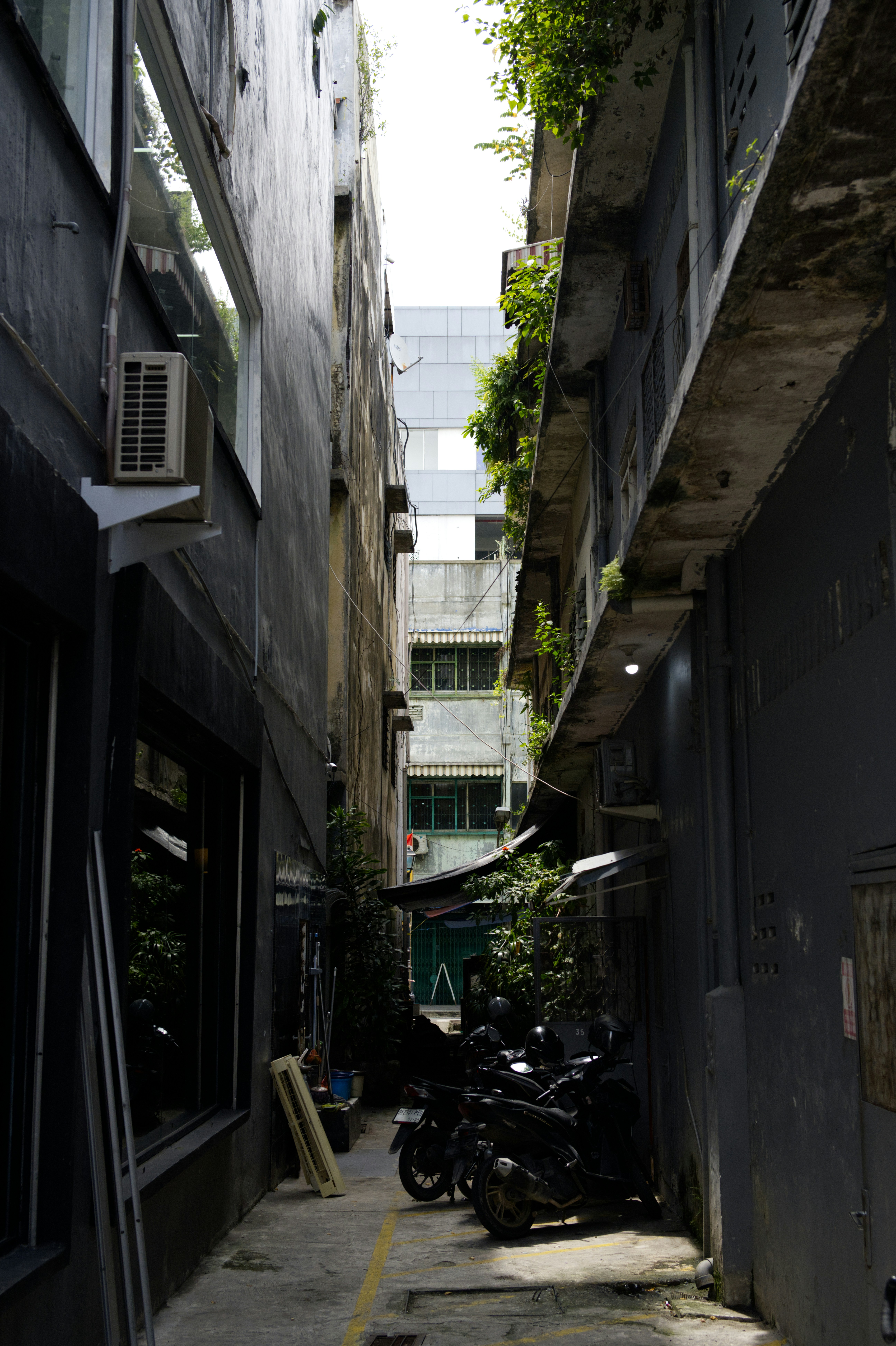 Narrow Alleyway Corridor with Dappled Light and Motorbikes