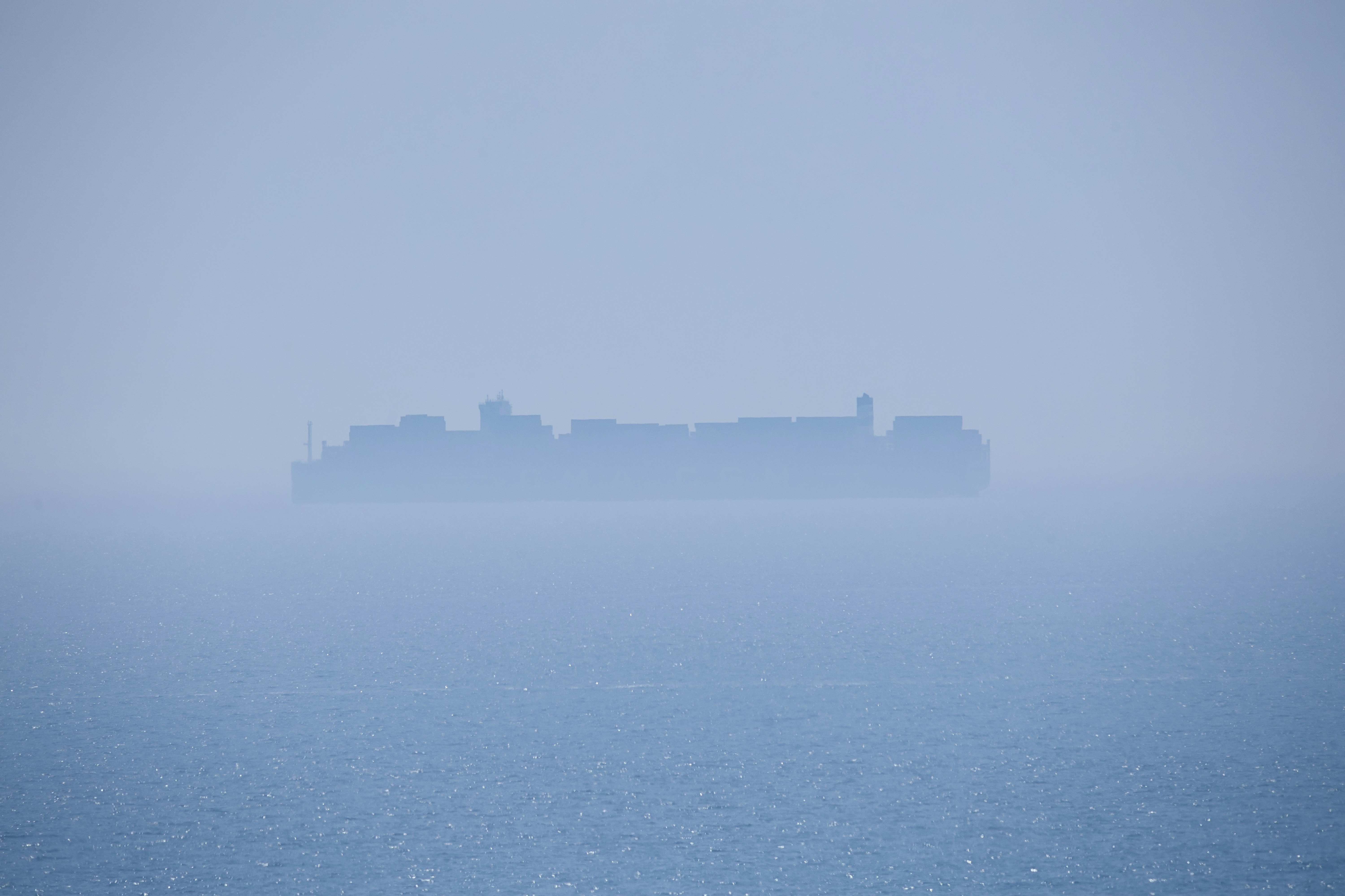 Hazy Arctic Hull: A Distant Vessel Quietly Rests on a Frosted Sea
