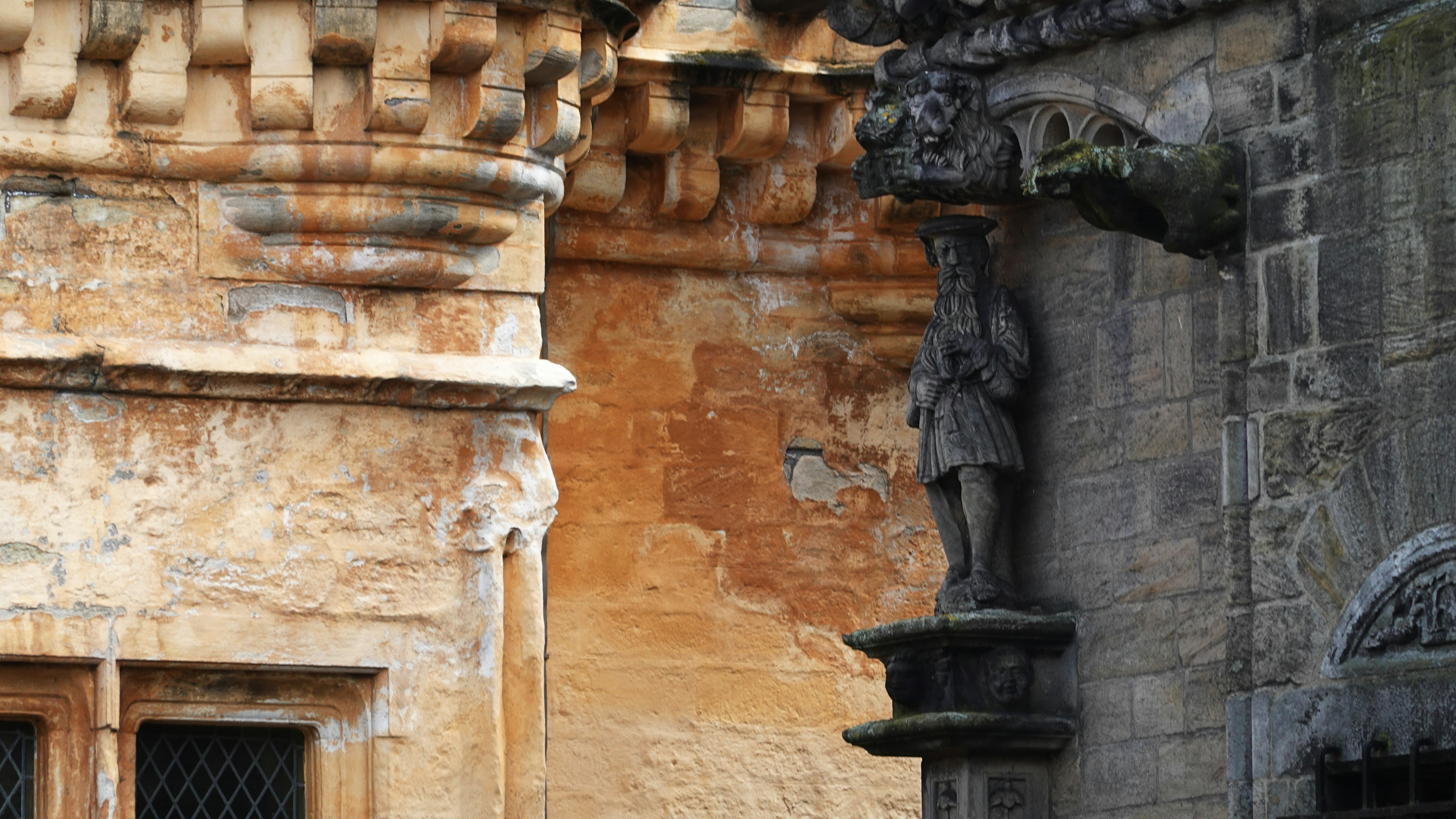 Stone Facade and Guard Figure: A Colonial Wall in Sunlit Sepia