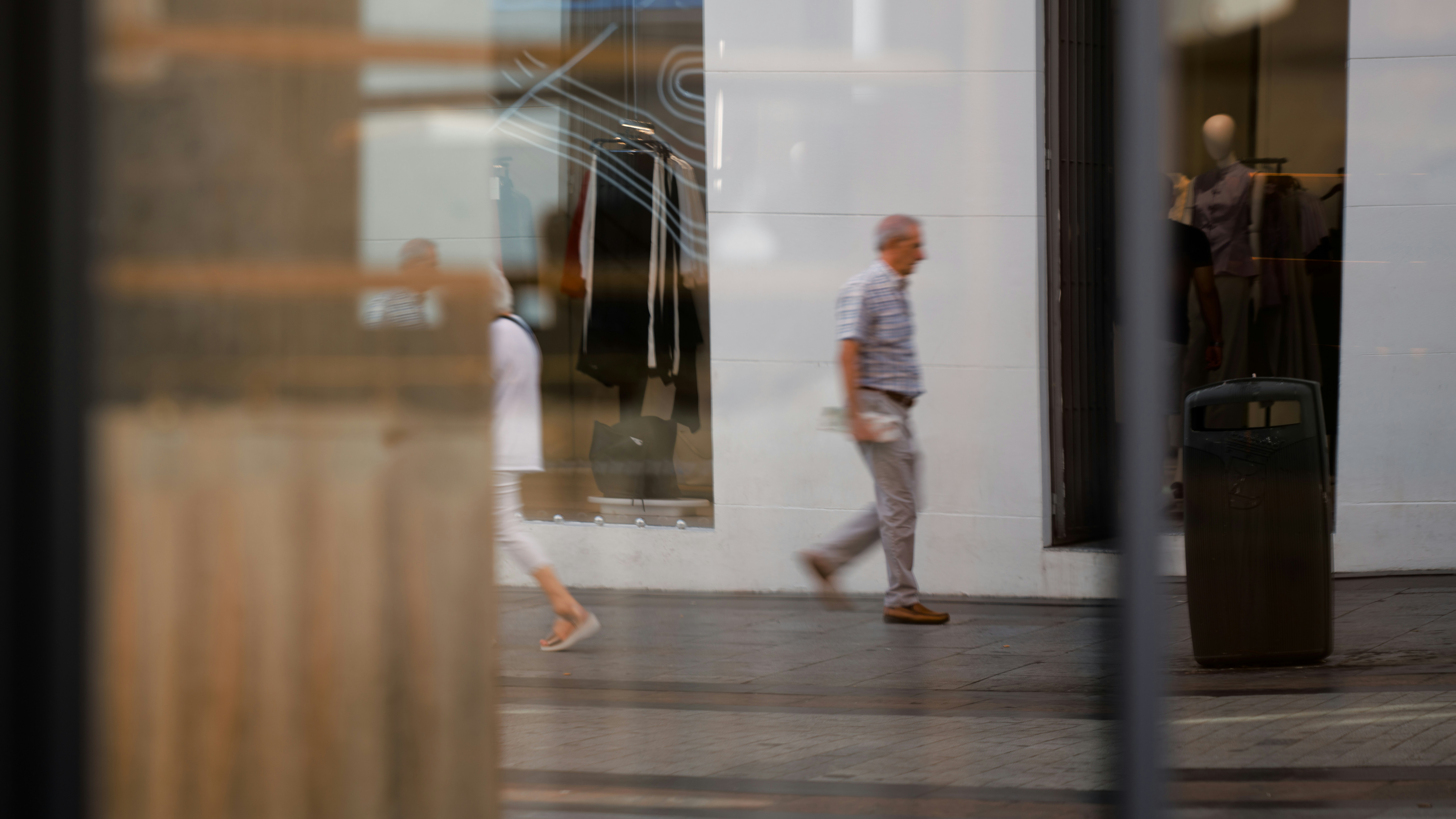 Passerby in a Quiet Glass-Walled Gallery Lane