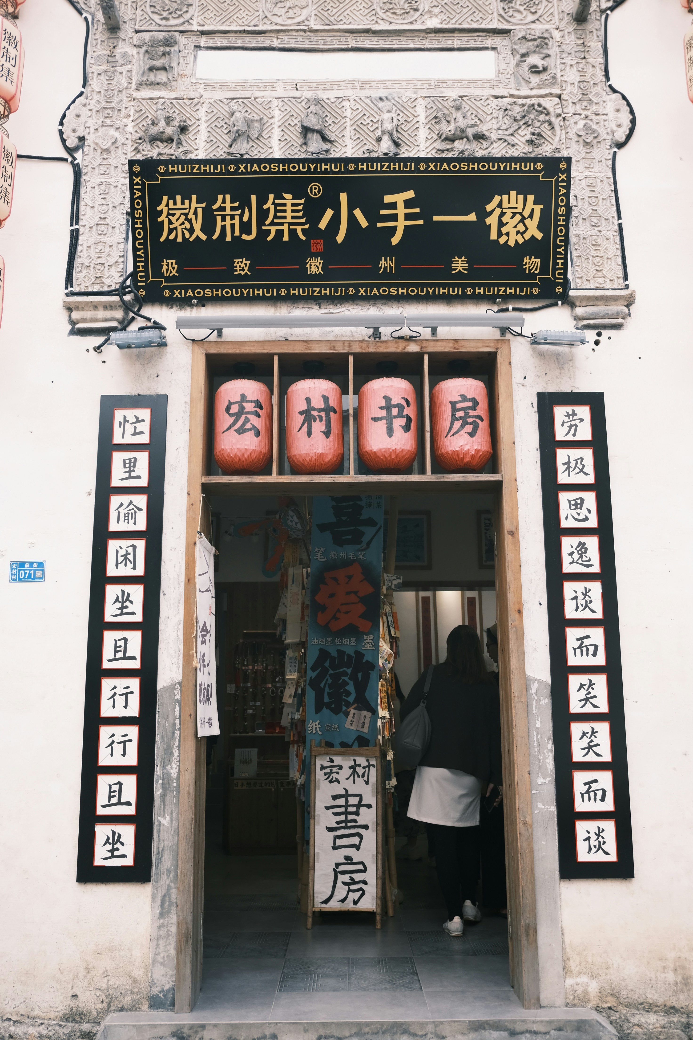Entrance to a Chinese storefront with hanging lanterns and carved stone arch