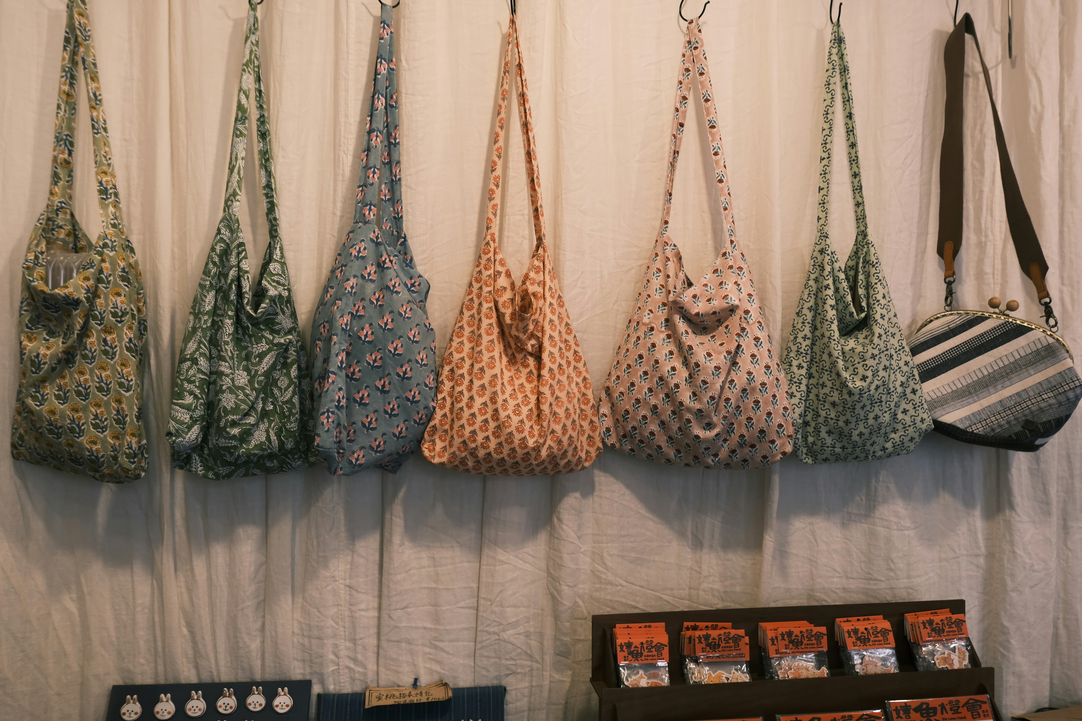 Row of patterned bags at a soft-lit market stall