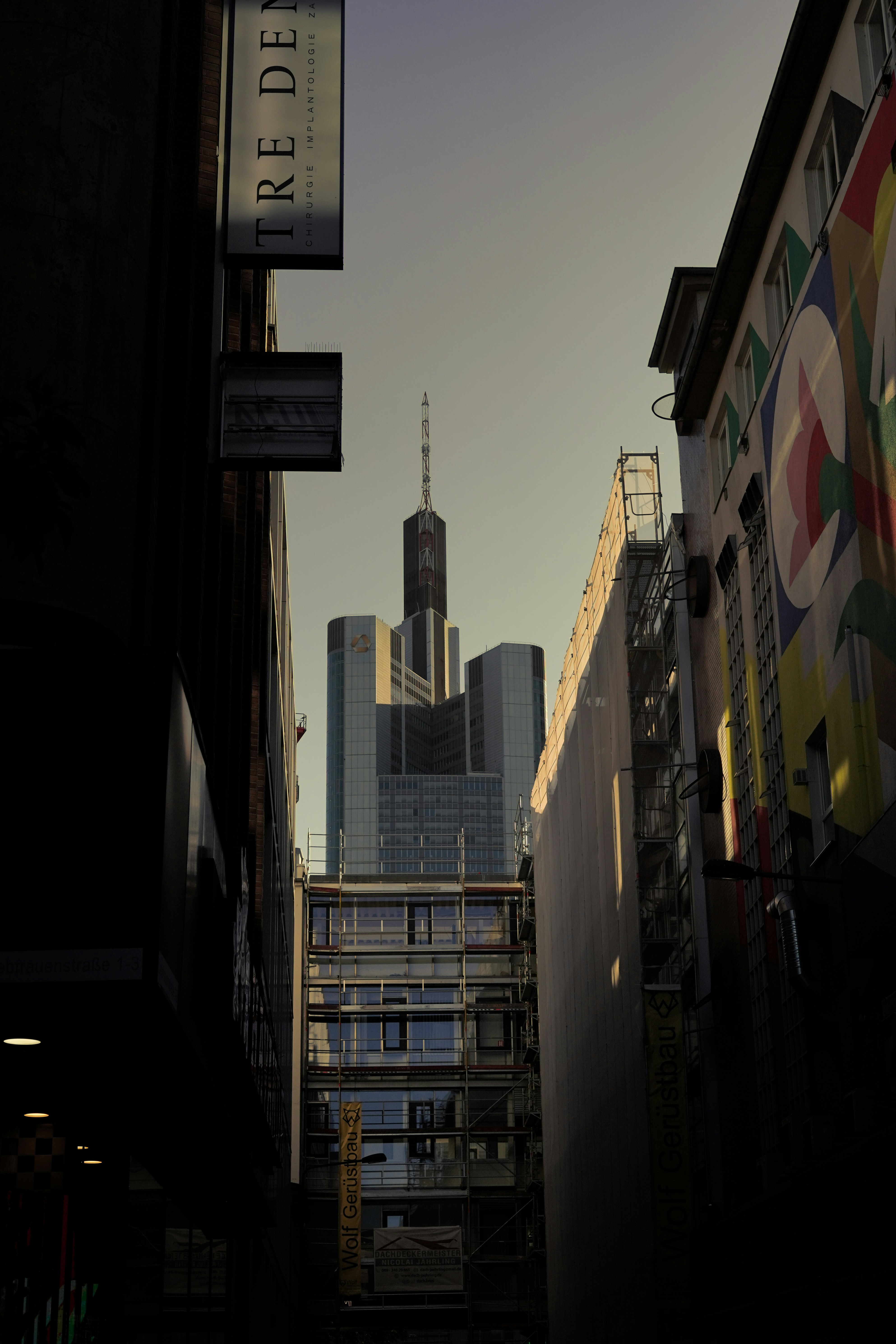 Urban Canyon: Skyscraper Needle Peeking Between Shaded Streets