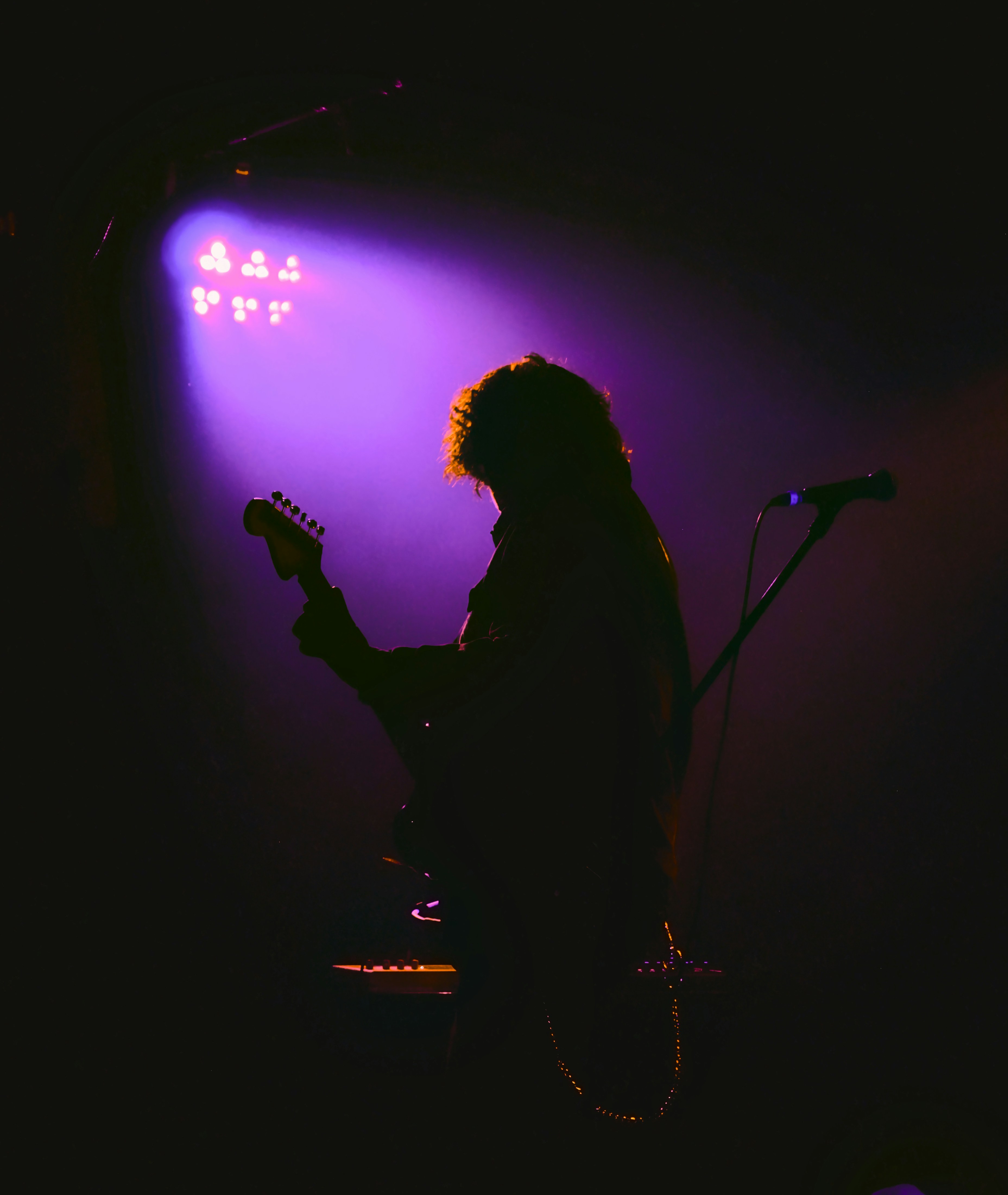 Silhouette of the Guitarist in Violet Stage Light