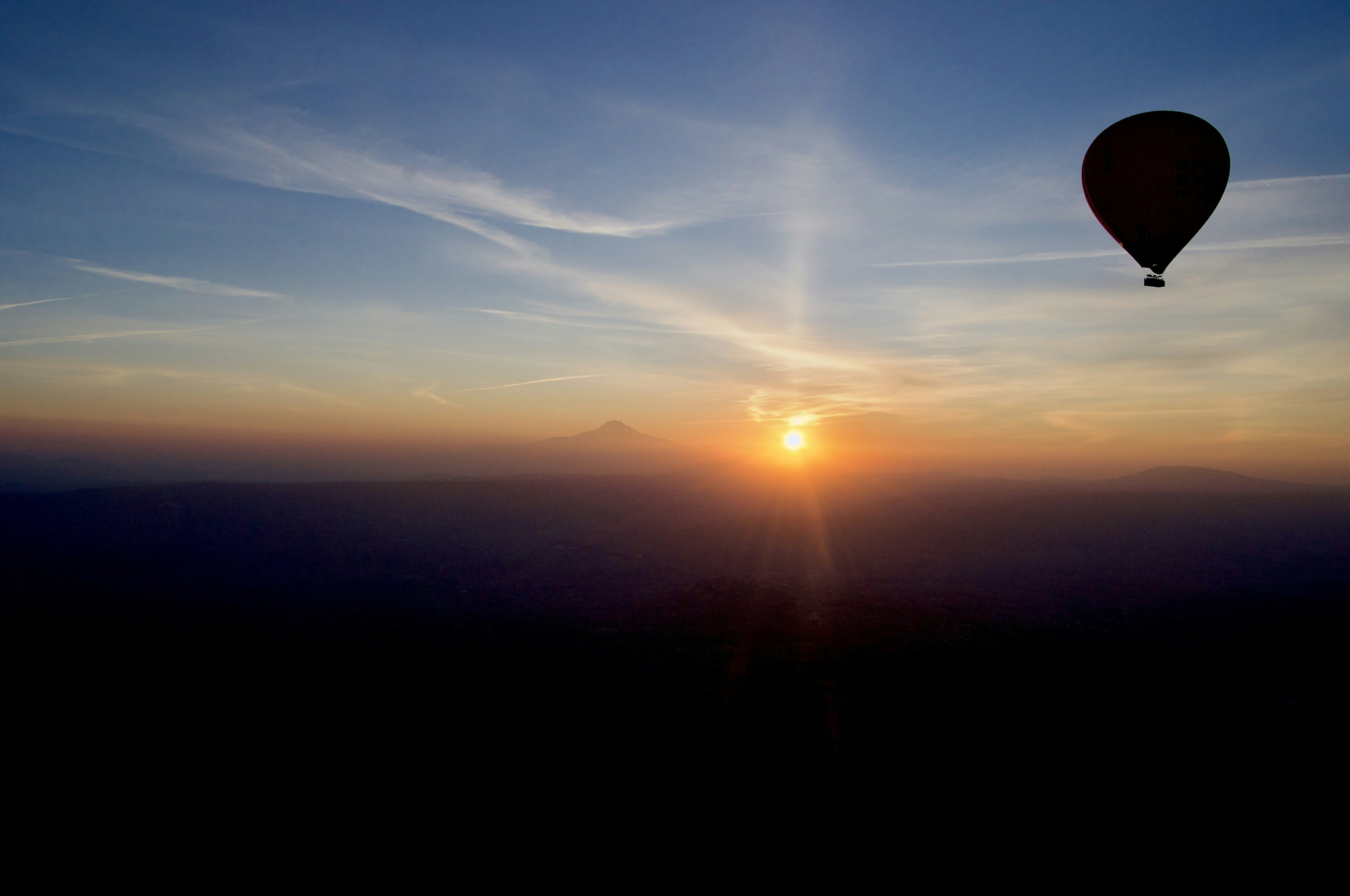 Sunrise Ascent: A Balloon Drifts Over a Quiet Horizon