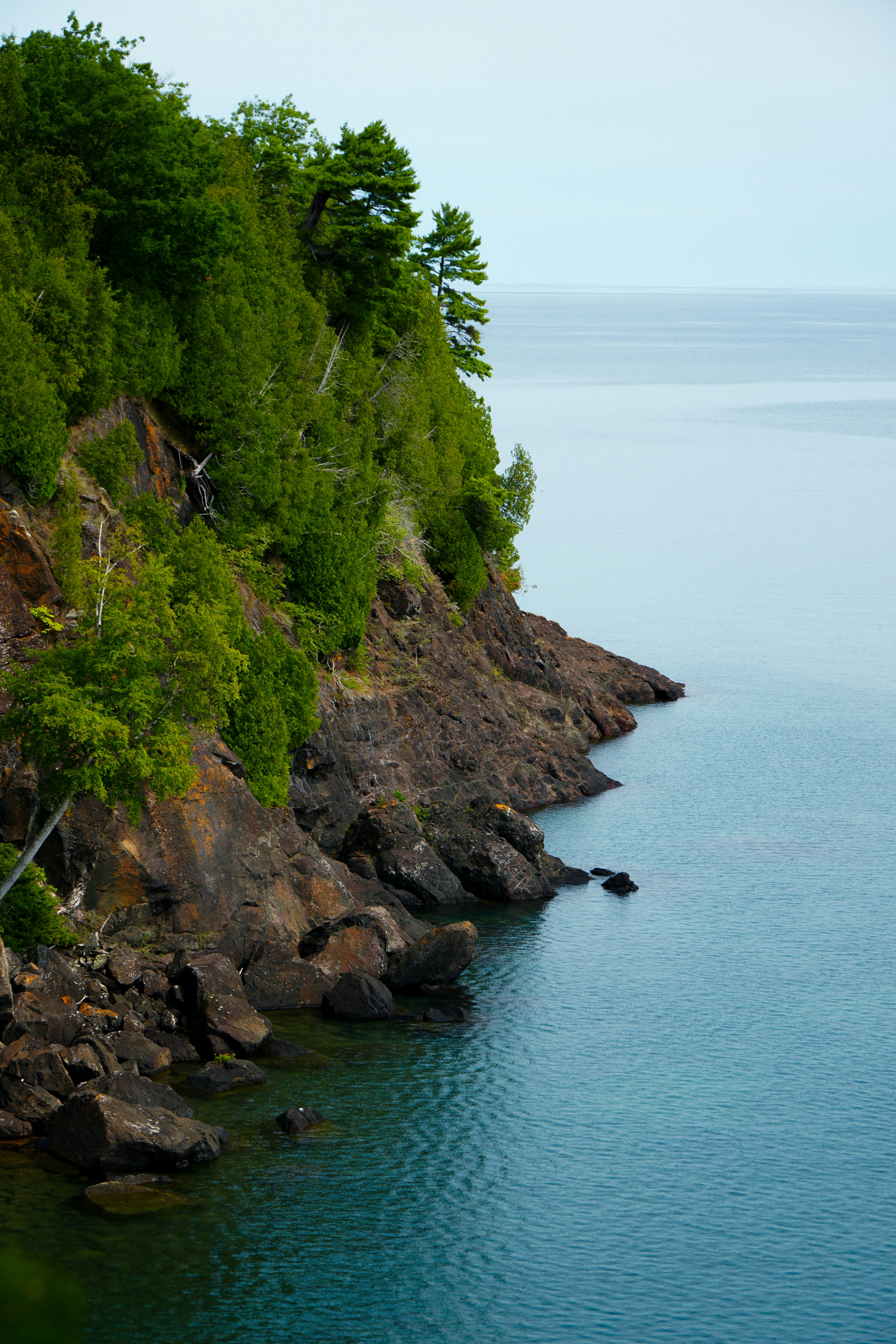 Cliffside Greenrise Over Quiet Waters