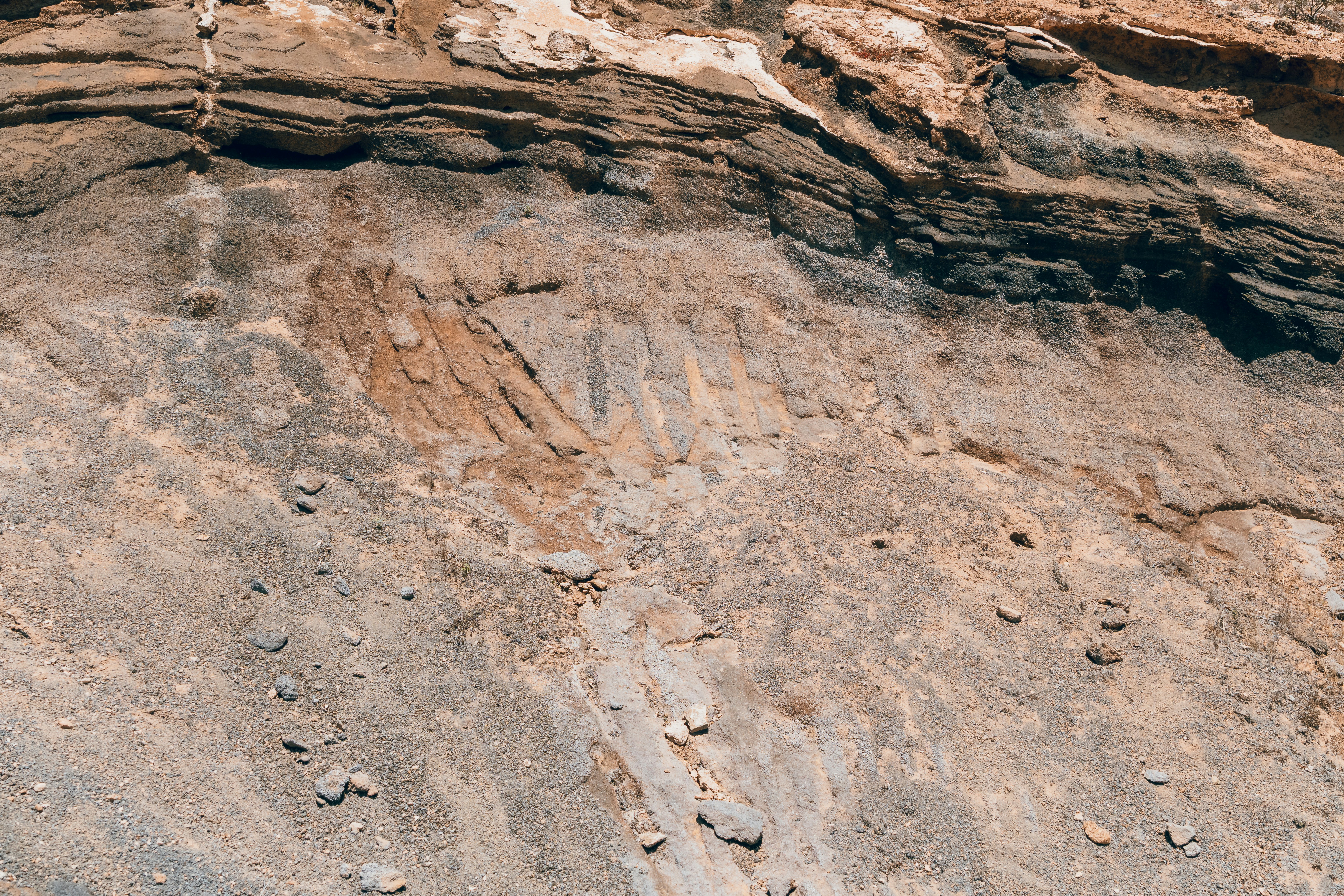 Eroded Stone Facade with Subtle Striations and Pebble Scatter