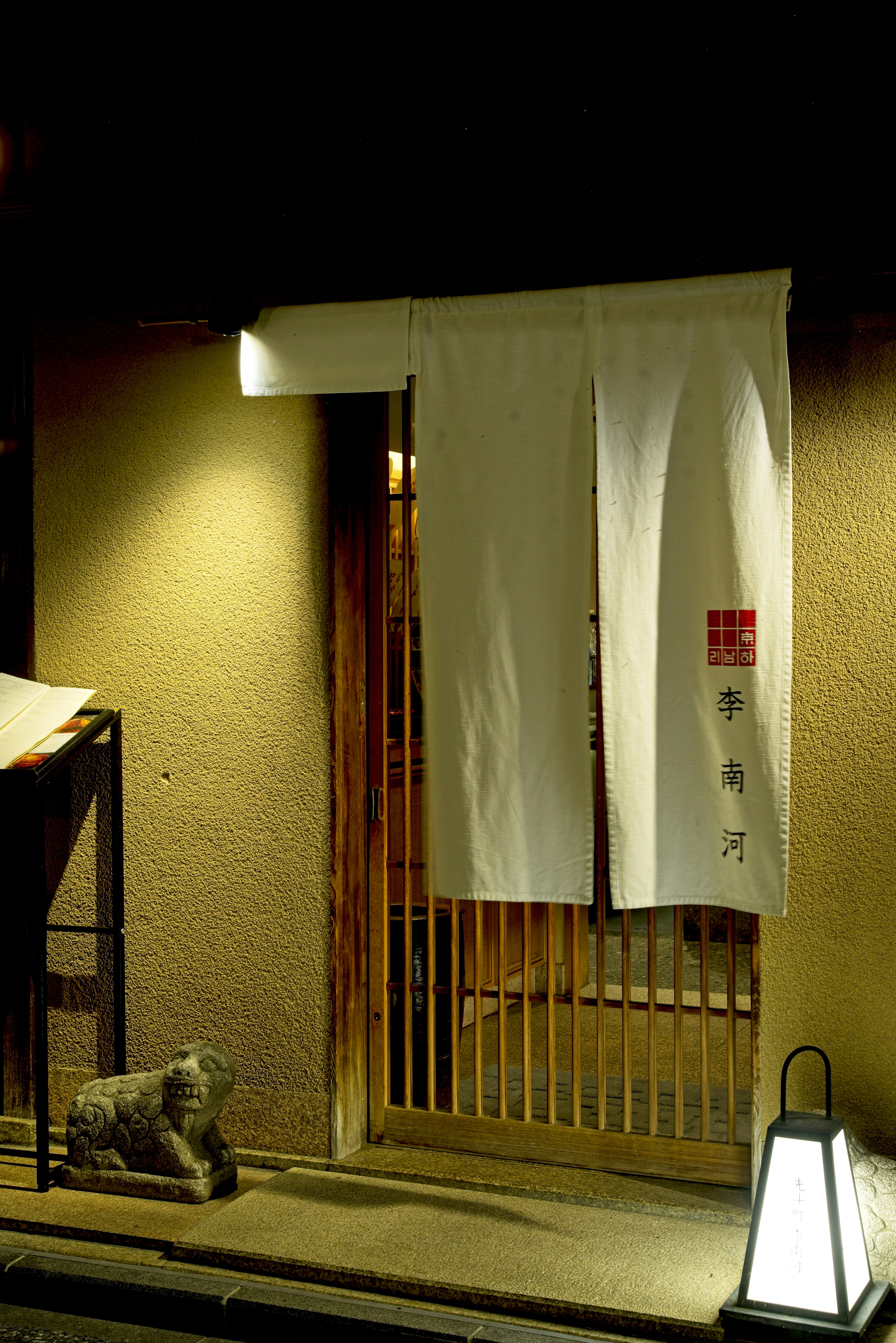 Entrance with Noren Curtain Illuminated by Soft Night Light