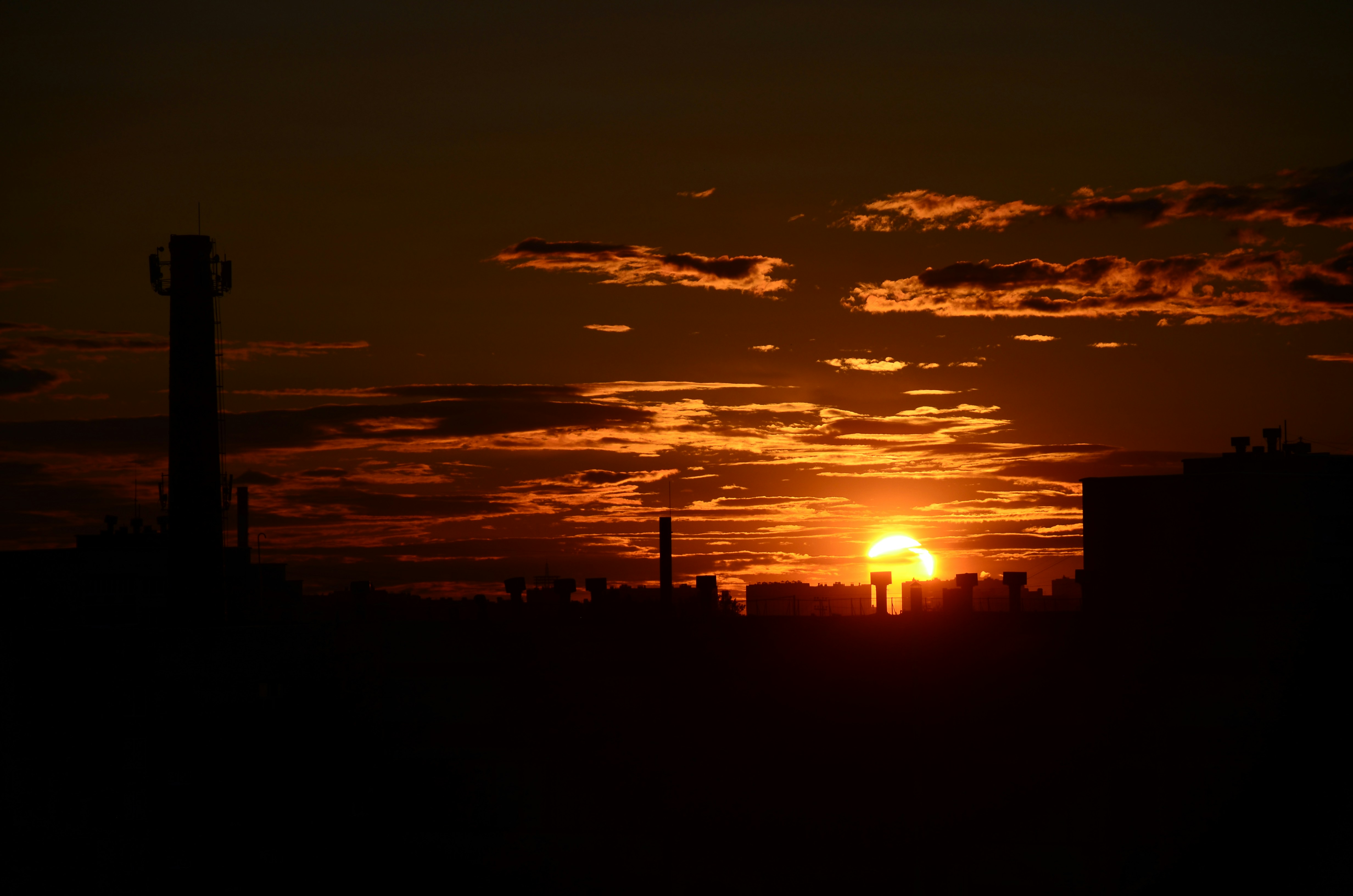 Dusk on the Horizon: Silent City Silhouette Against a Fiery Sky
