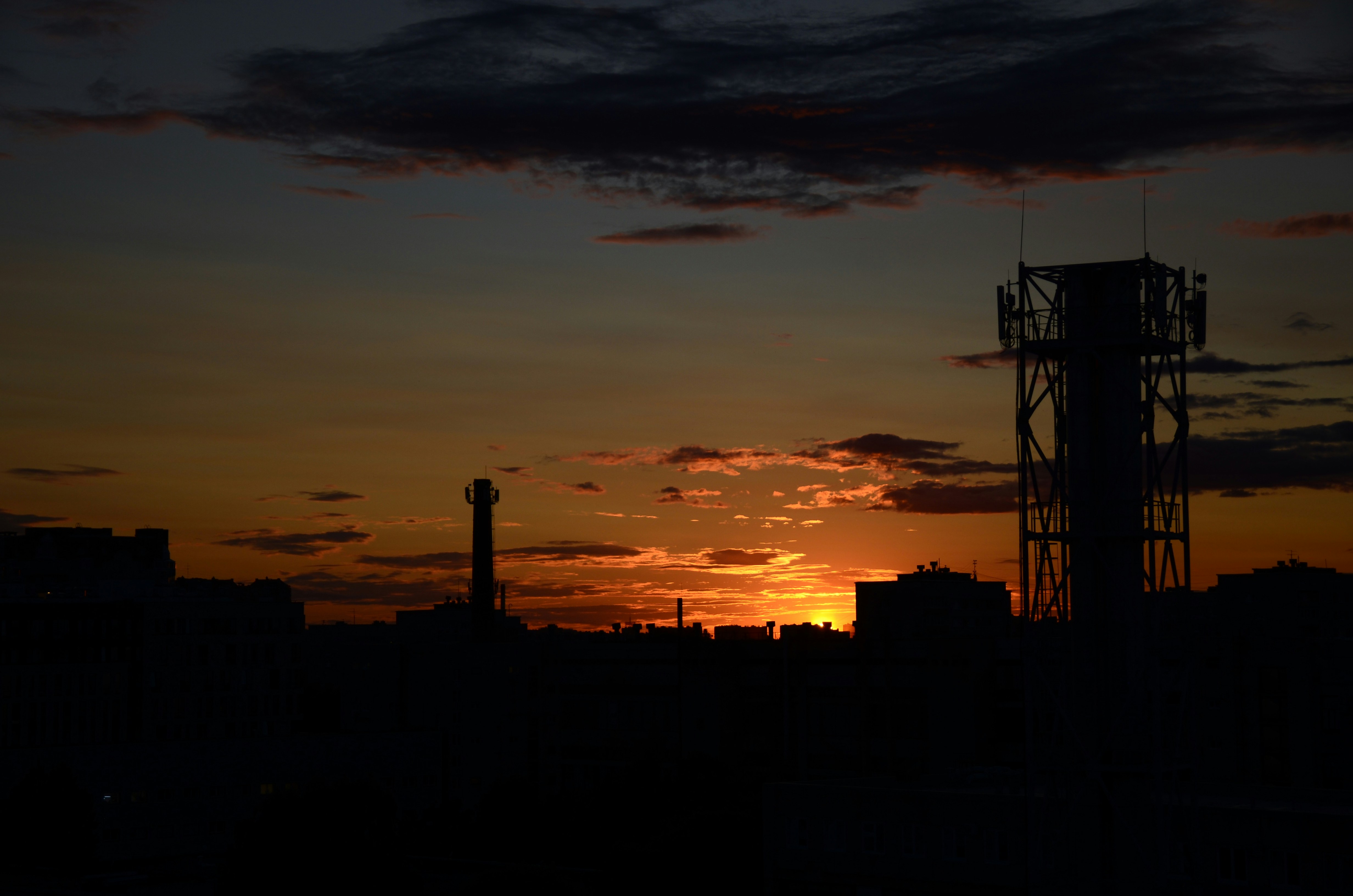 Sunset Silhouette Over Industrial Skyline