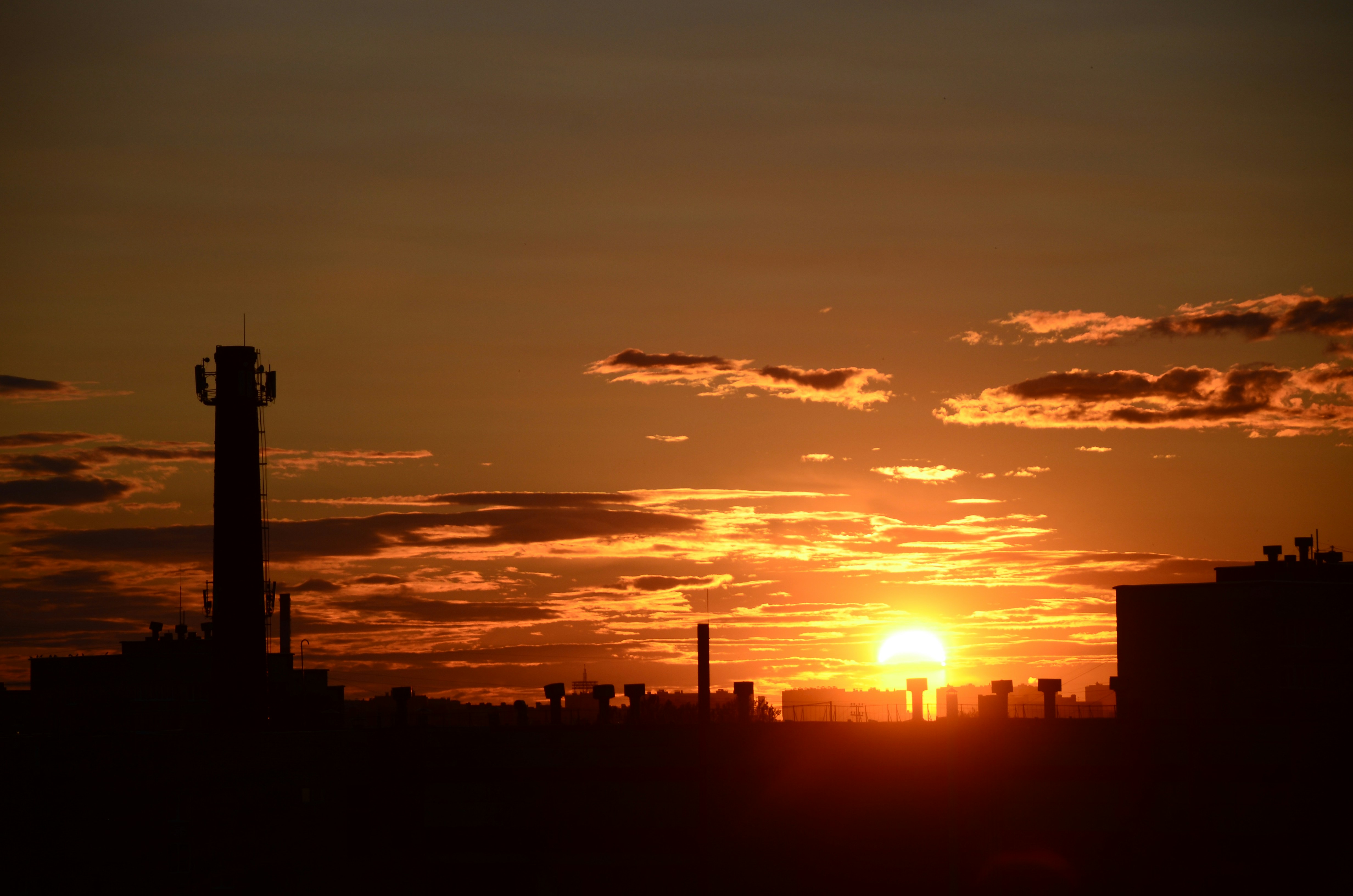 Silhouetted Skyline at Sunset with a Radiant Horizon