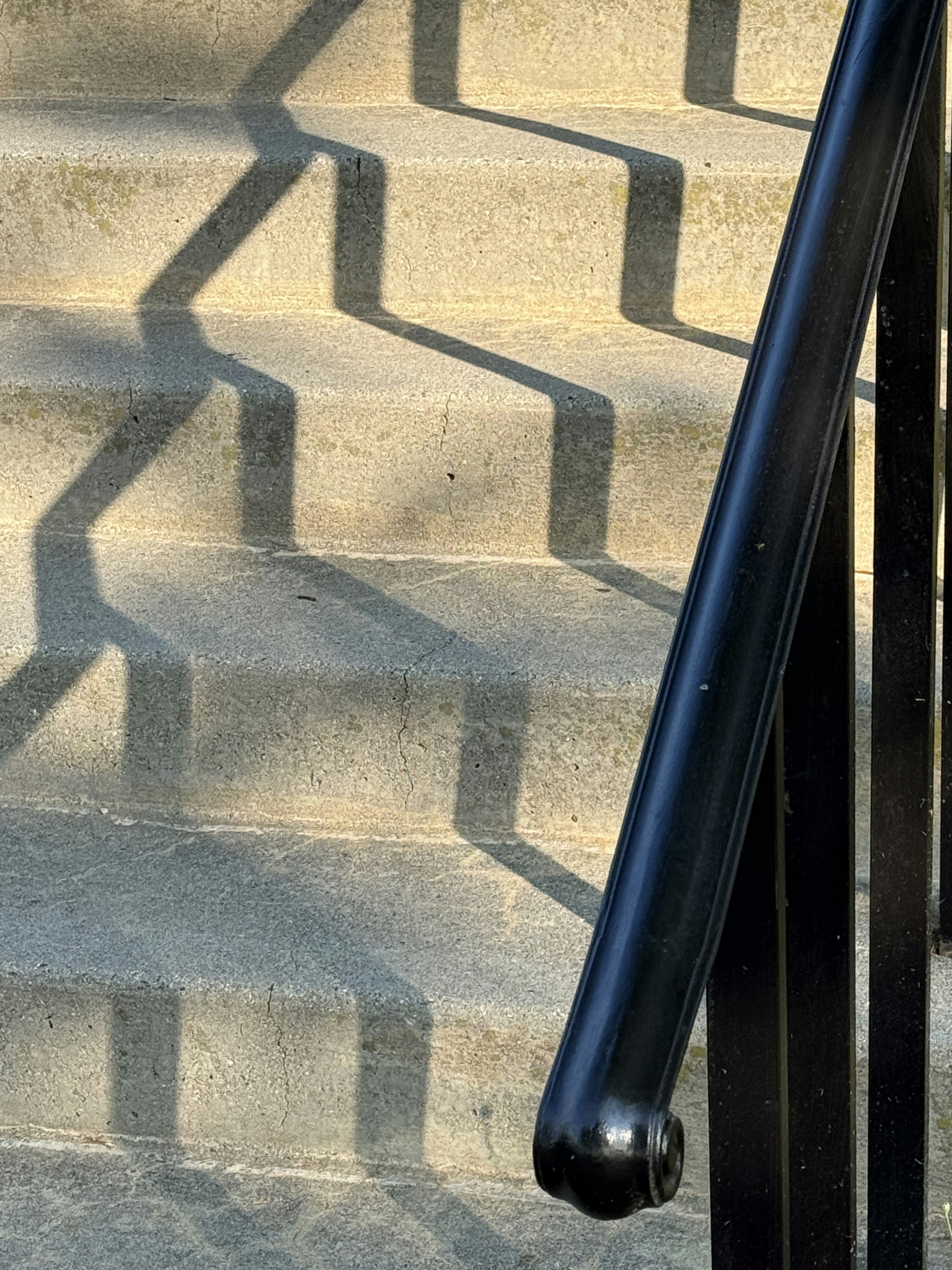 Shadowed steps and iron handrail: geometry in concrete