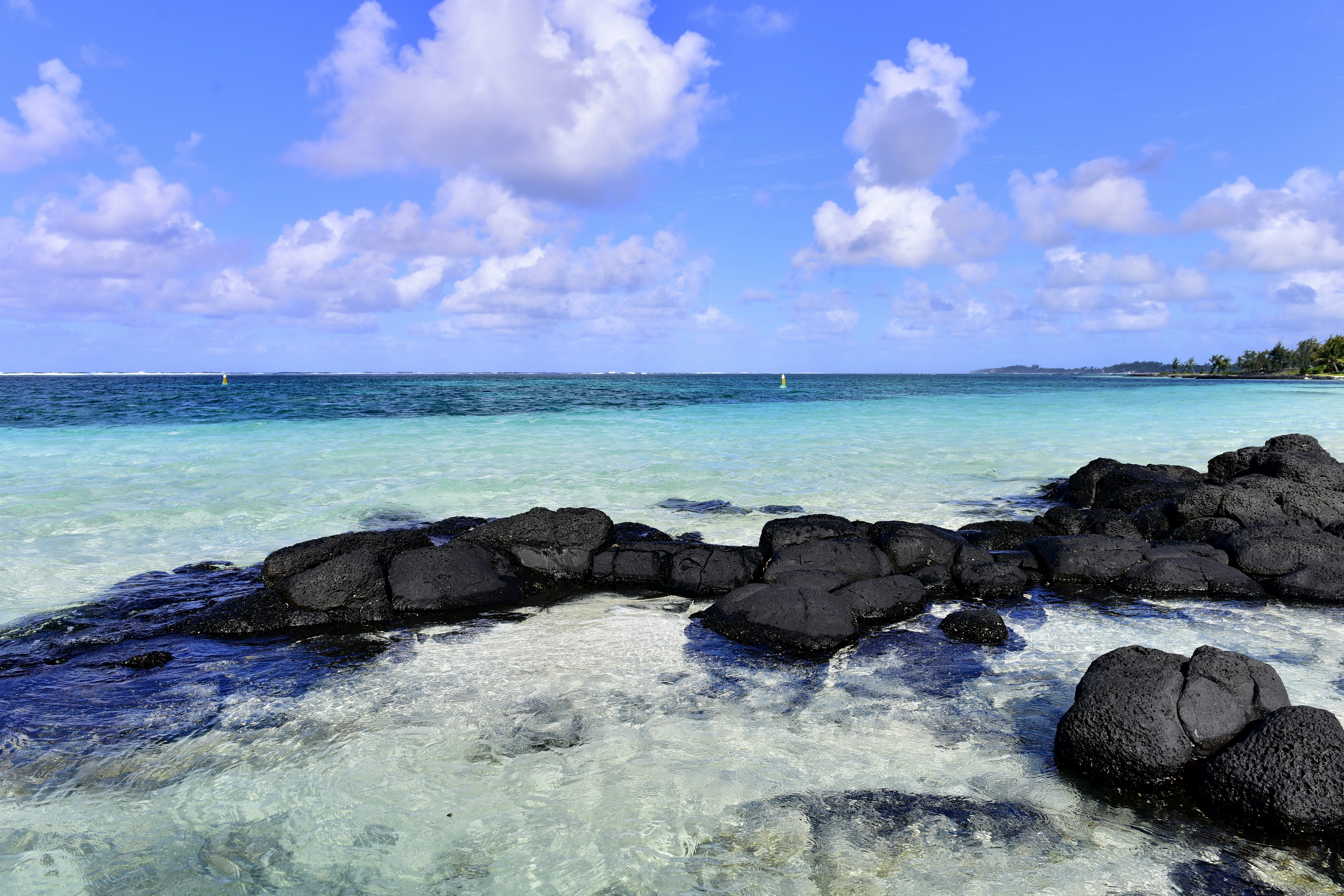 Shoreline Mosaic: Lava-like Rocks Meet Turquoise Waters