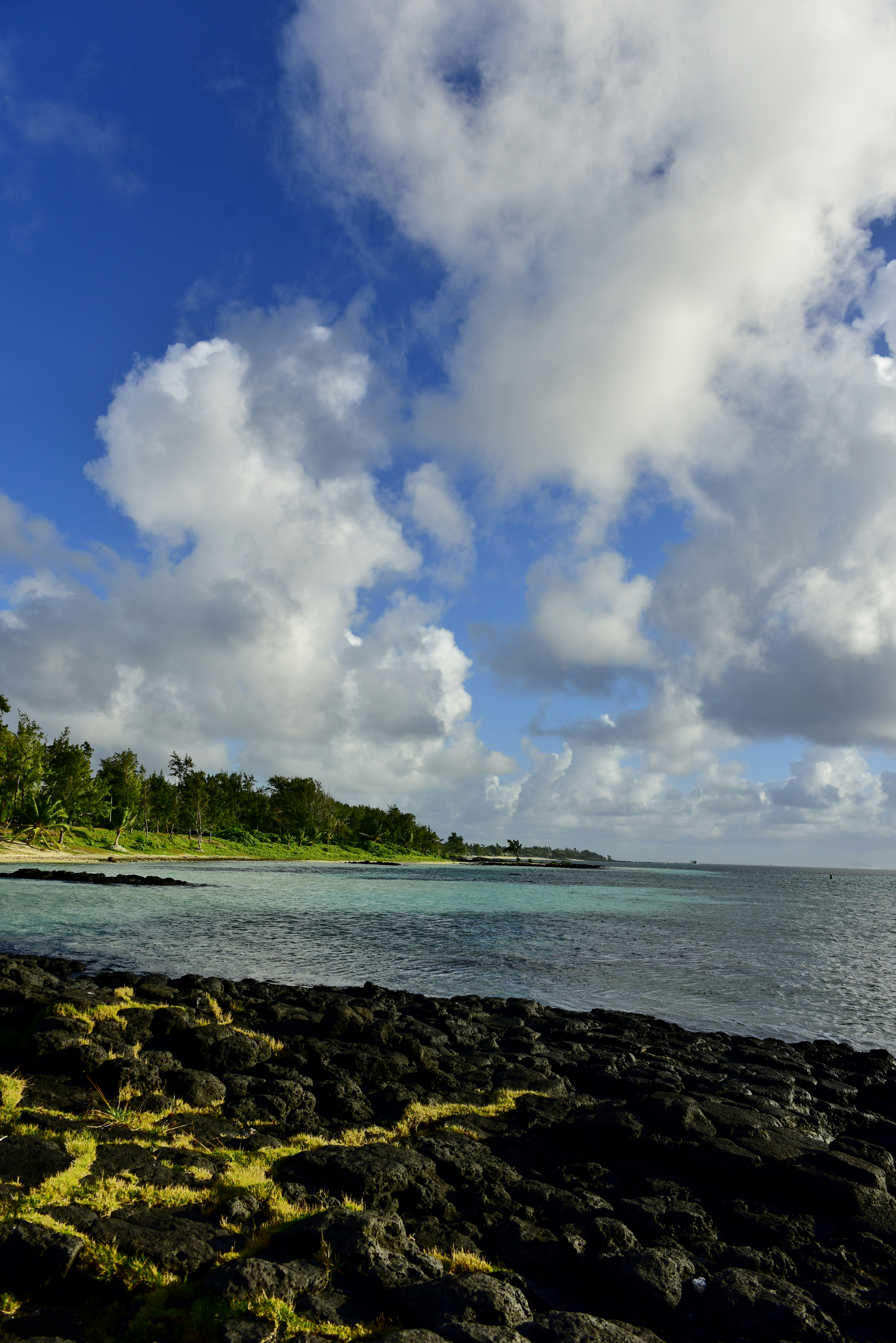 Lava-strewn shoreline under a vast Caribbean sky