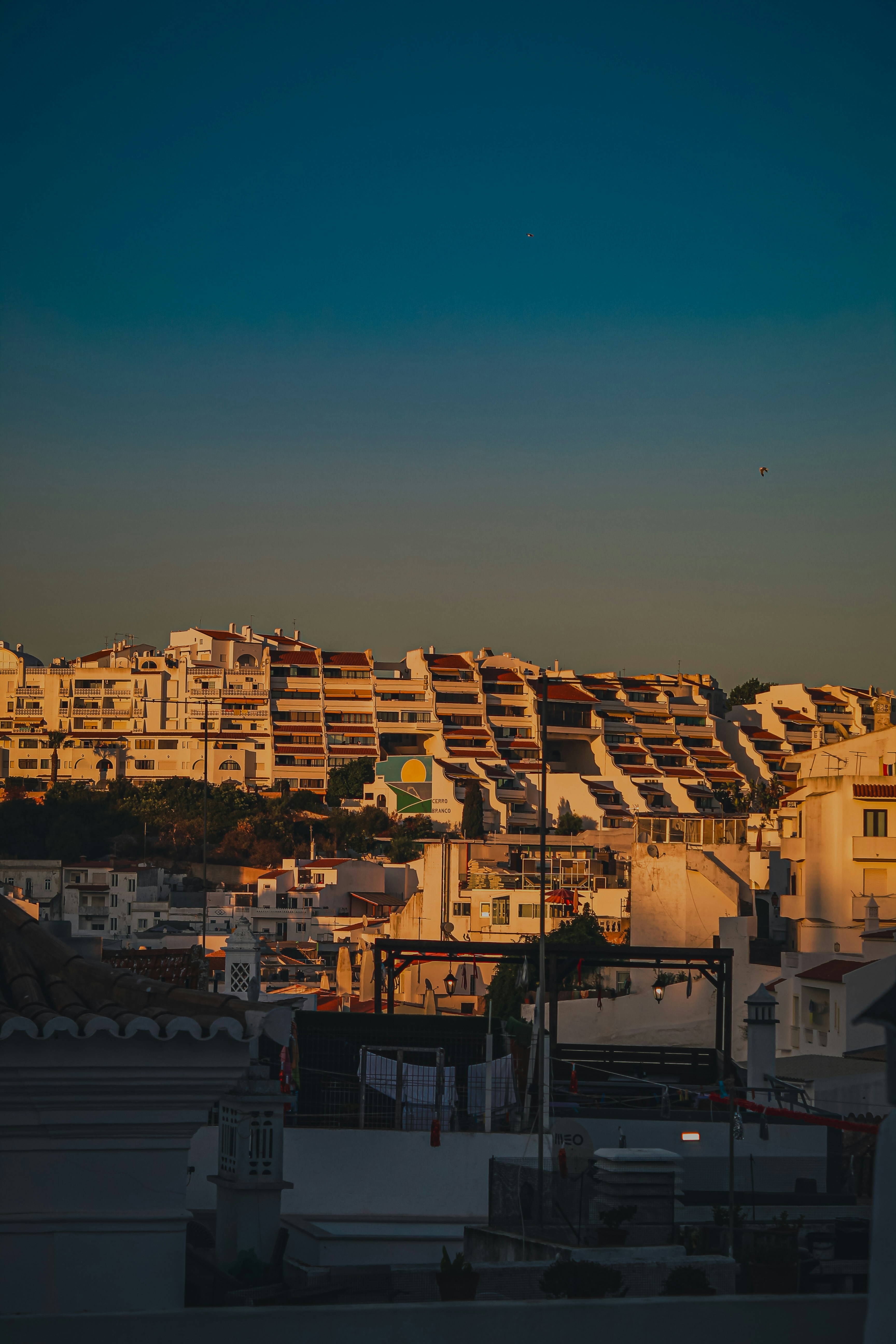 Terraced Mediterranean Quest: Sunlit White Buildings Ascend a Quiet Hillside