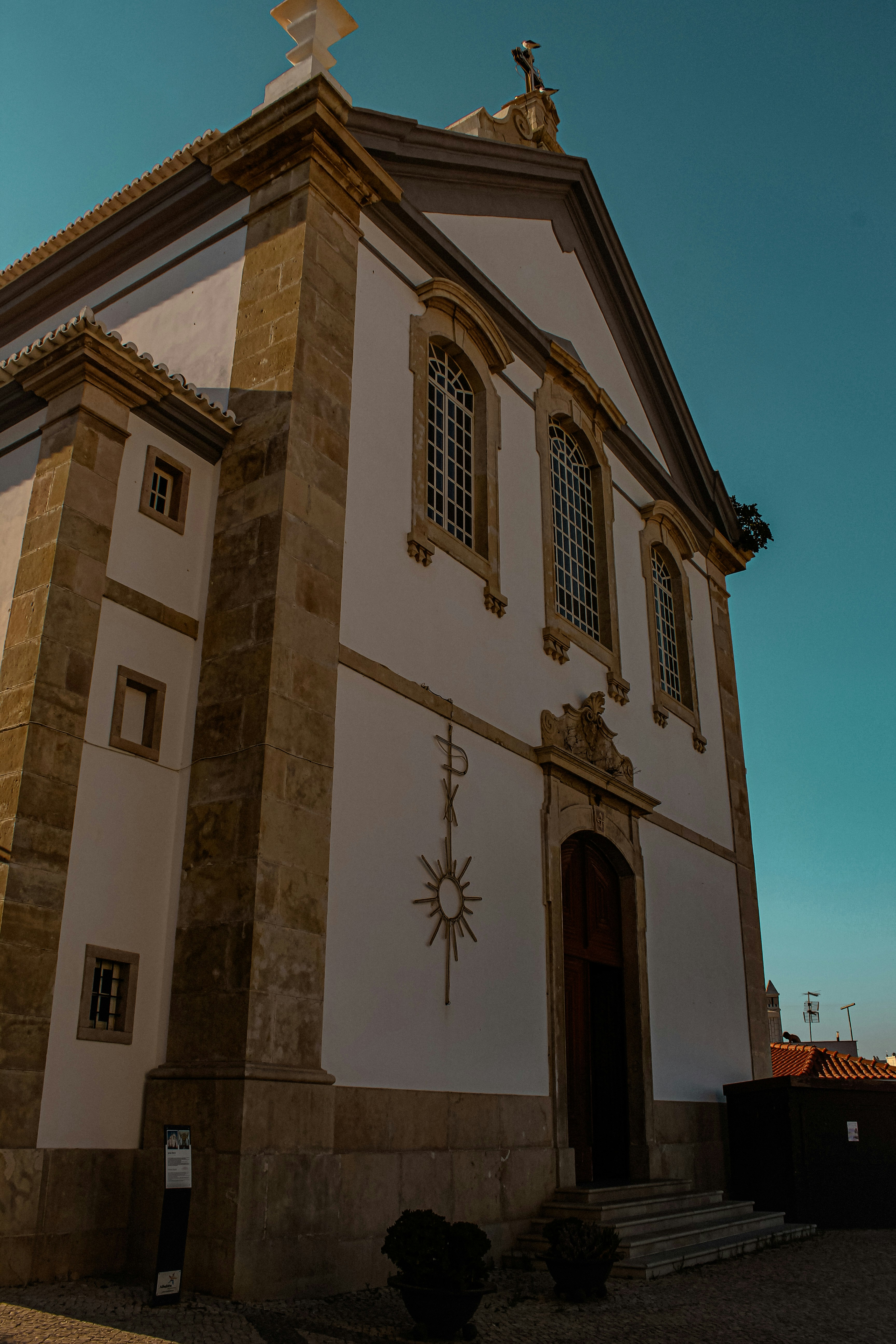 Sunlit Facade of a Historic Church with Statuary Crest
