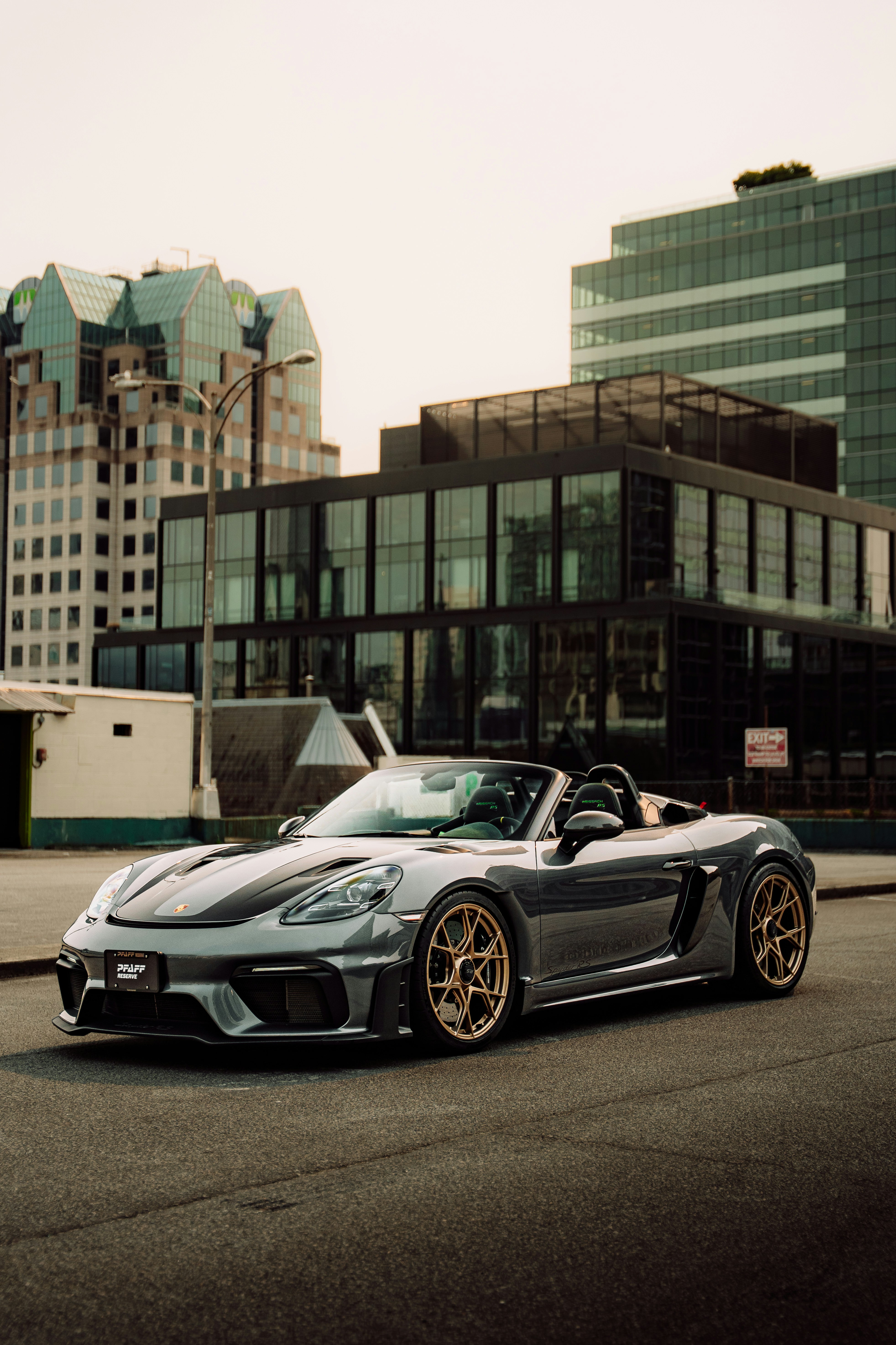 Low-angle view of a silver Porsche 911 Cabriolet parked in an urban lot