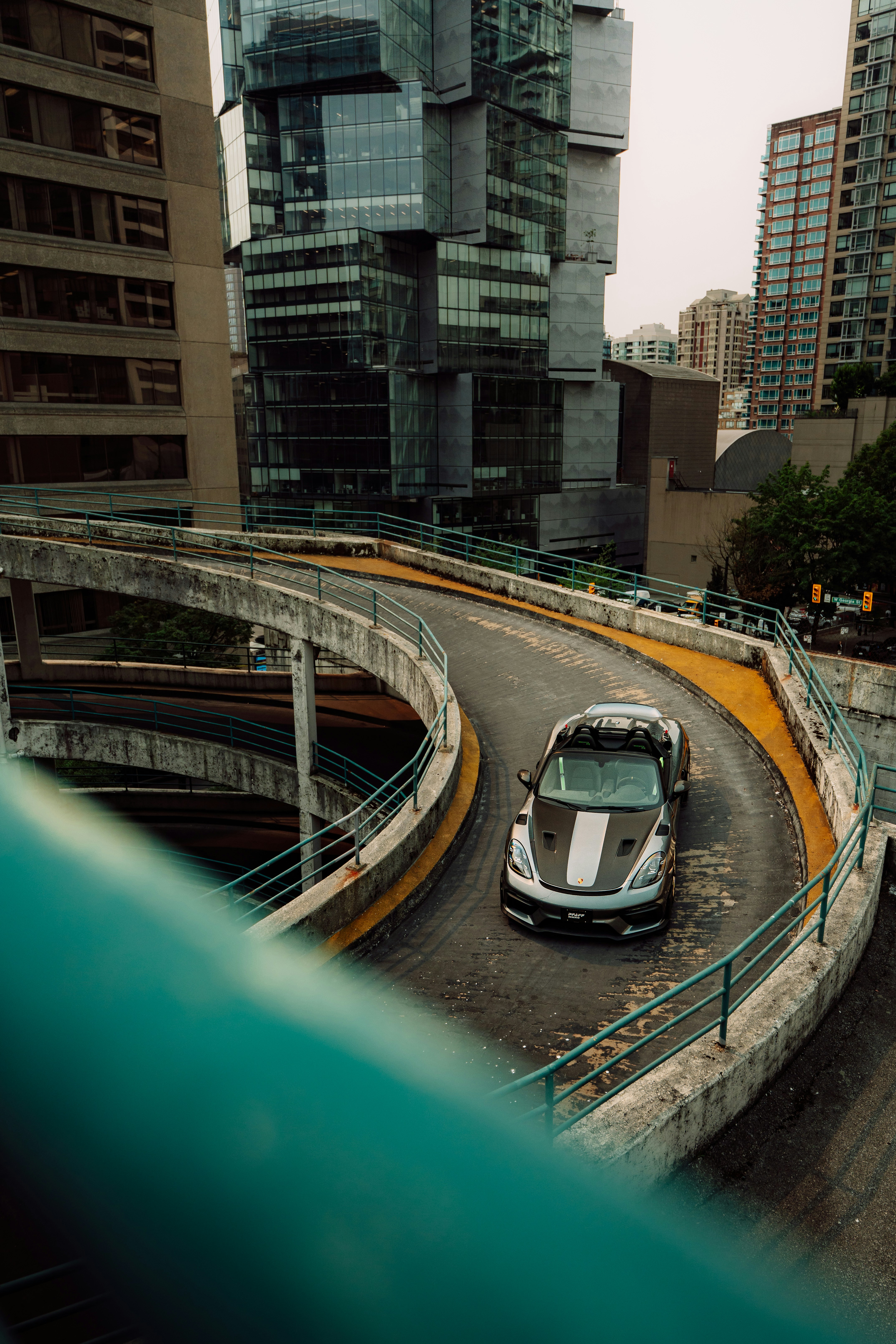 Corkscrew Ascent: A Silver Car Navigates a City Spiral