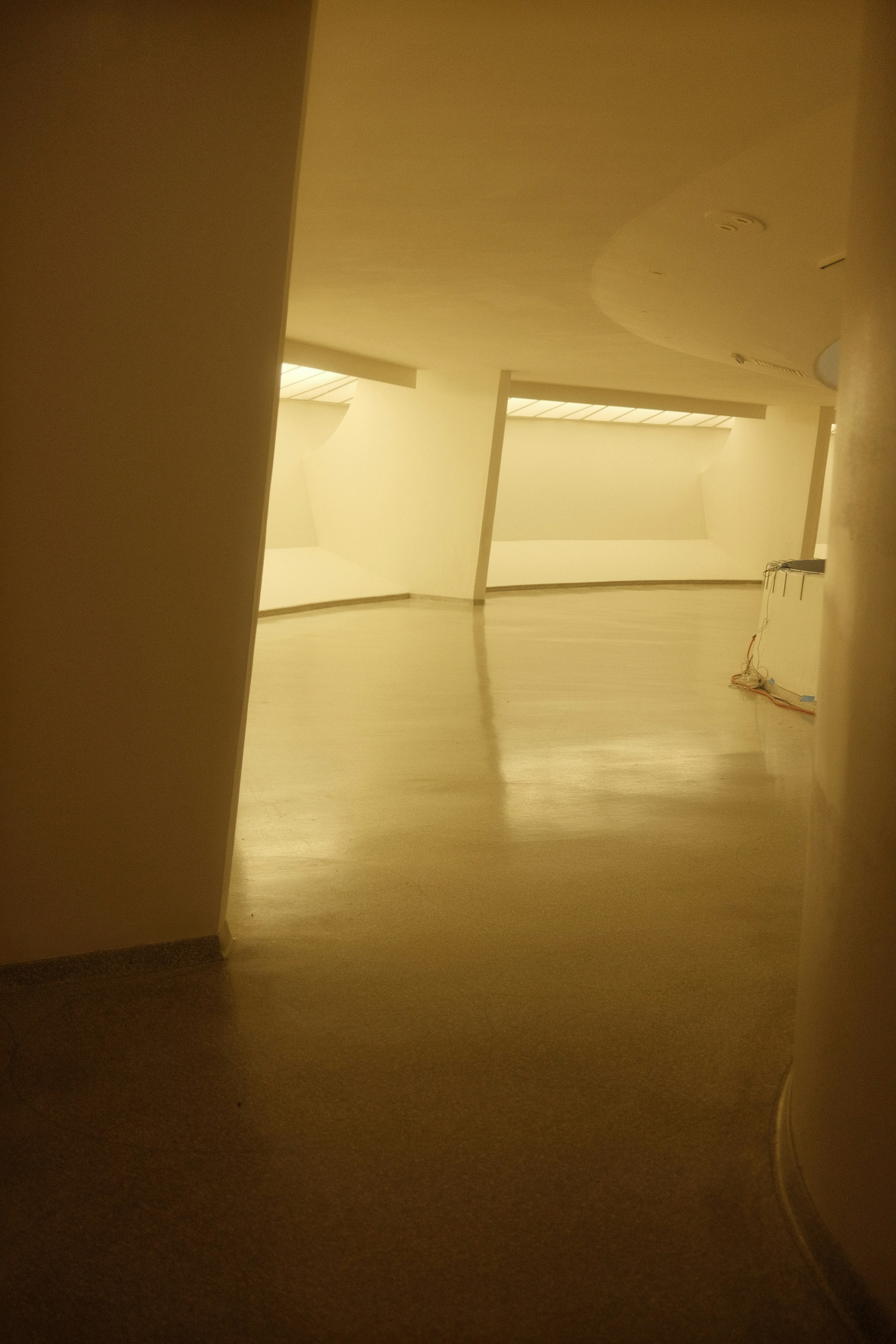 Curved corridor of warm light and quiet echoes
