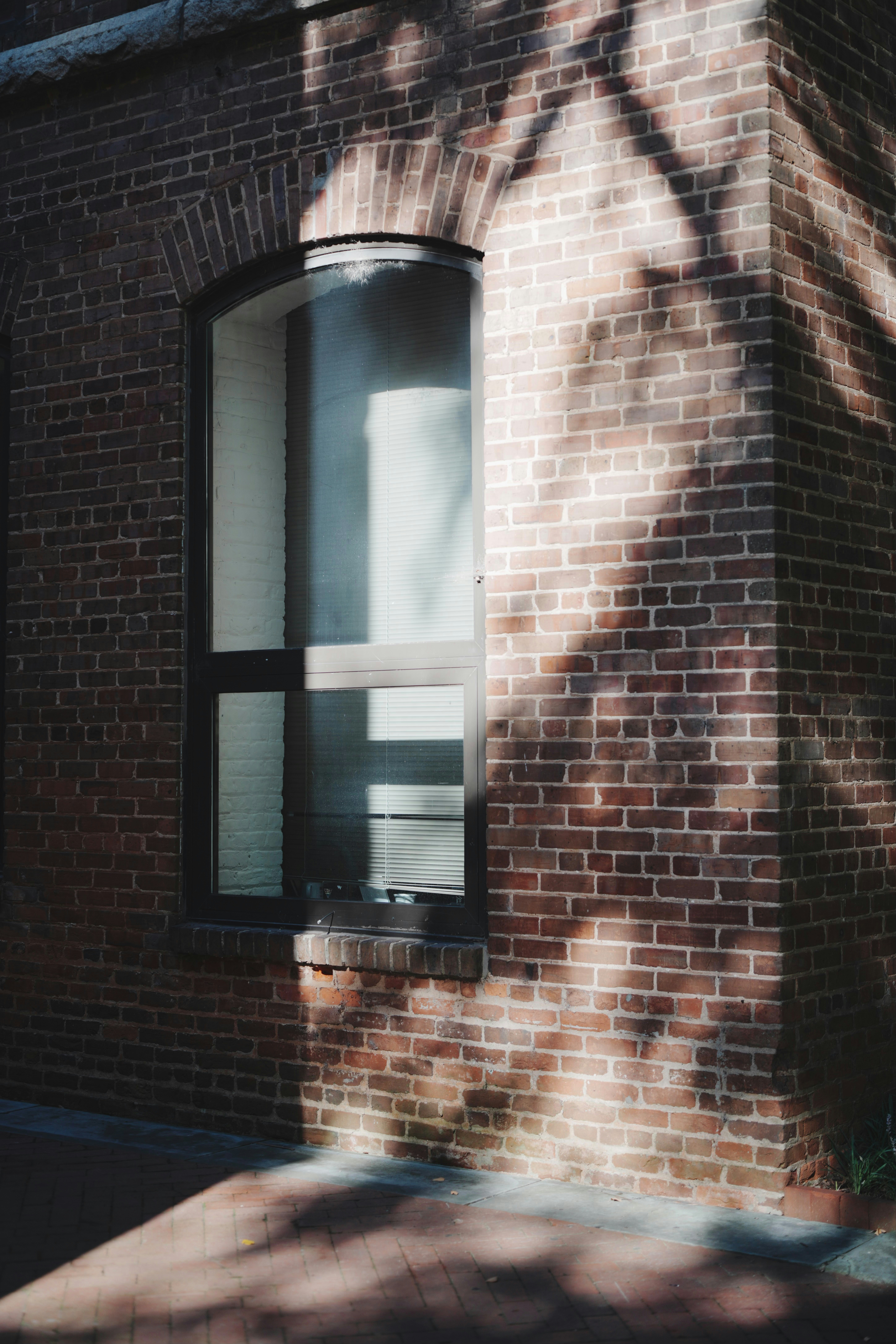 Shadowed Arch Window in Brick Wall