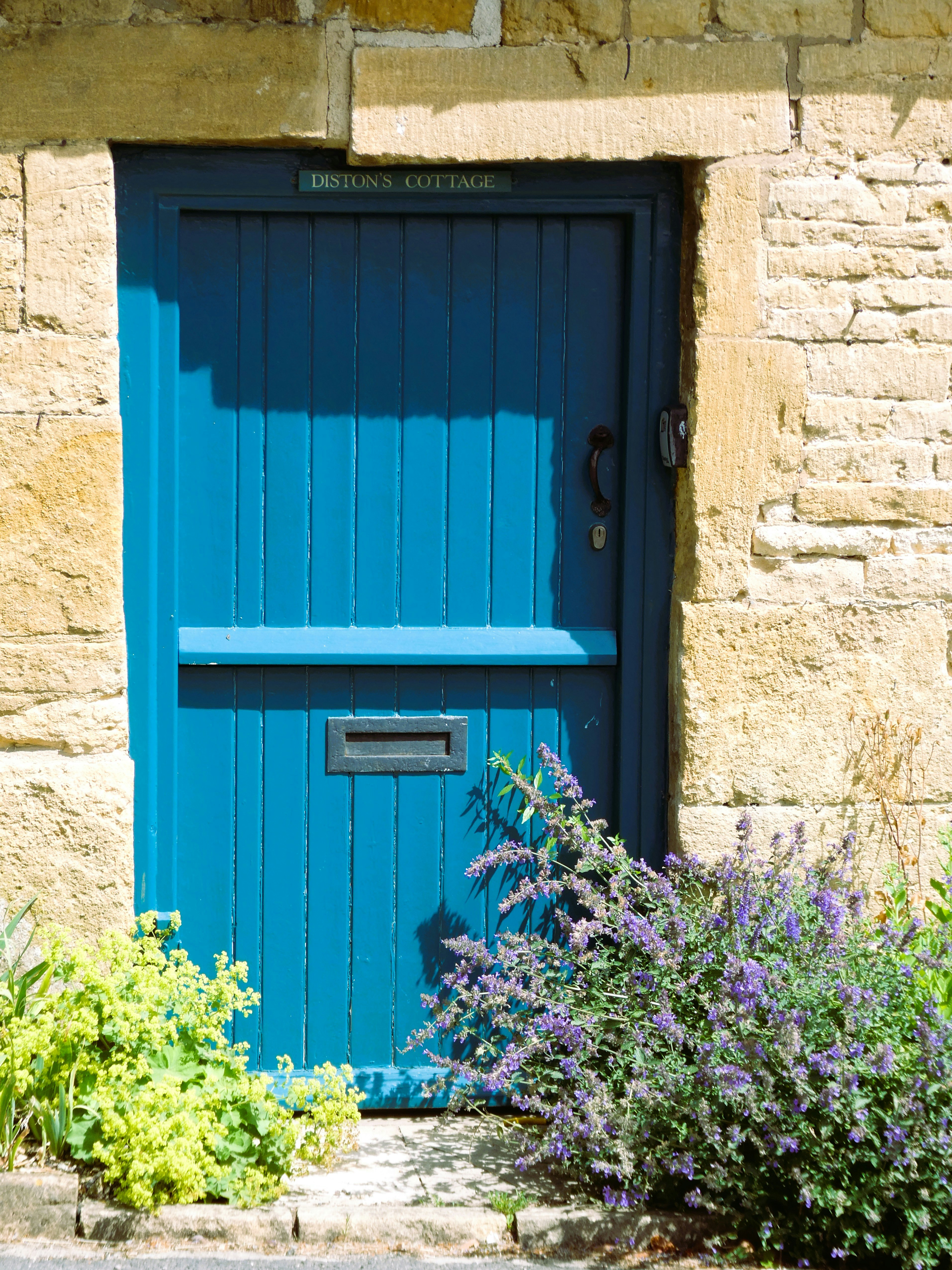 Azure Cottage Doorway: A Blue Portal set in Sunlit Stone
