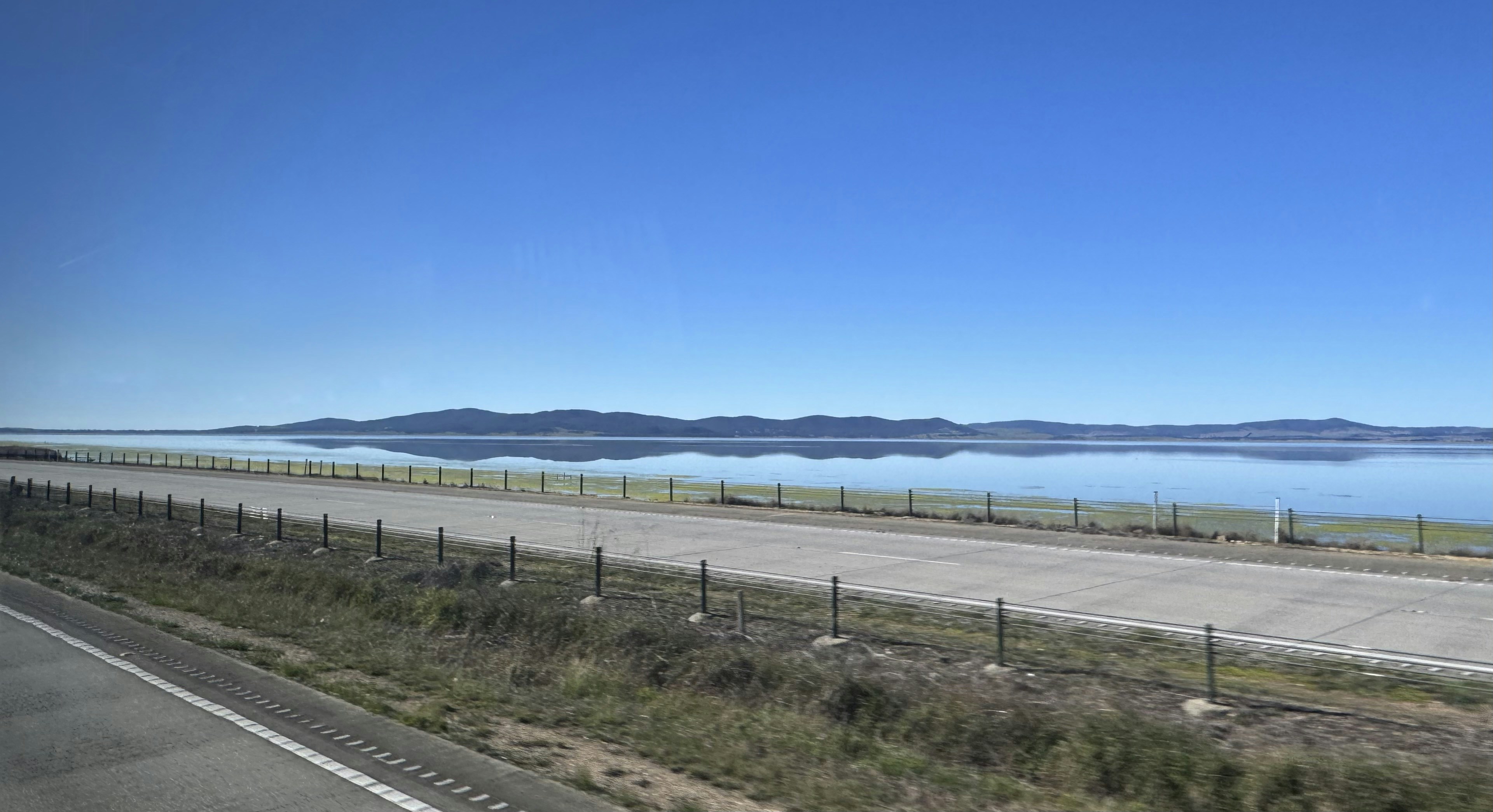 Roadside Horizon: Quiet Lagoon Under a Cerulean Sky