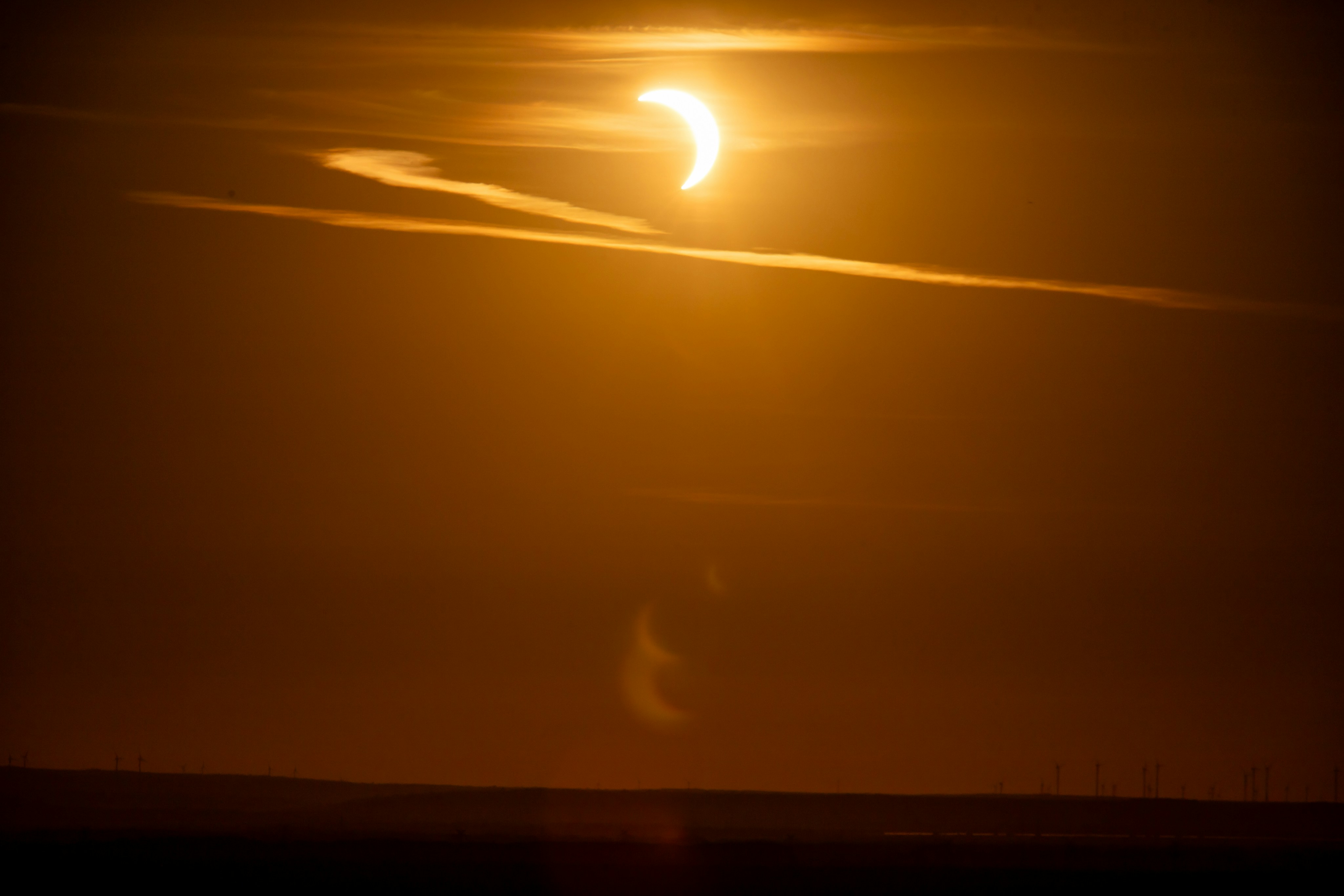 Eclipse in Orange Horizon: A Quiet Dusk Over Flat Lands