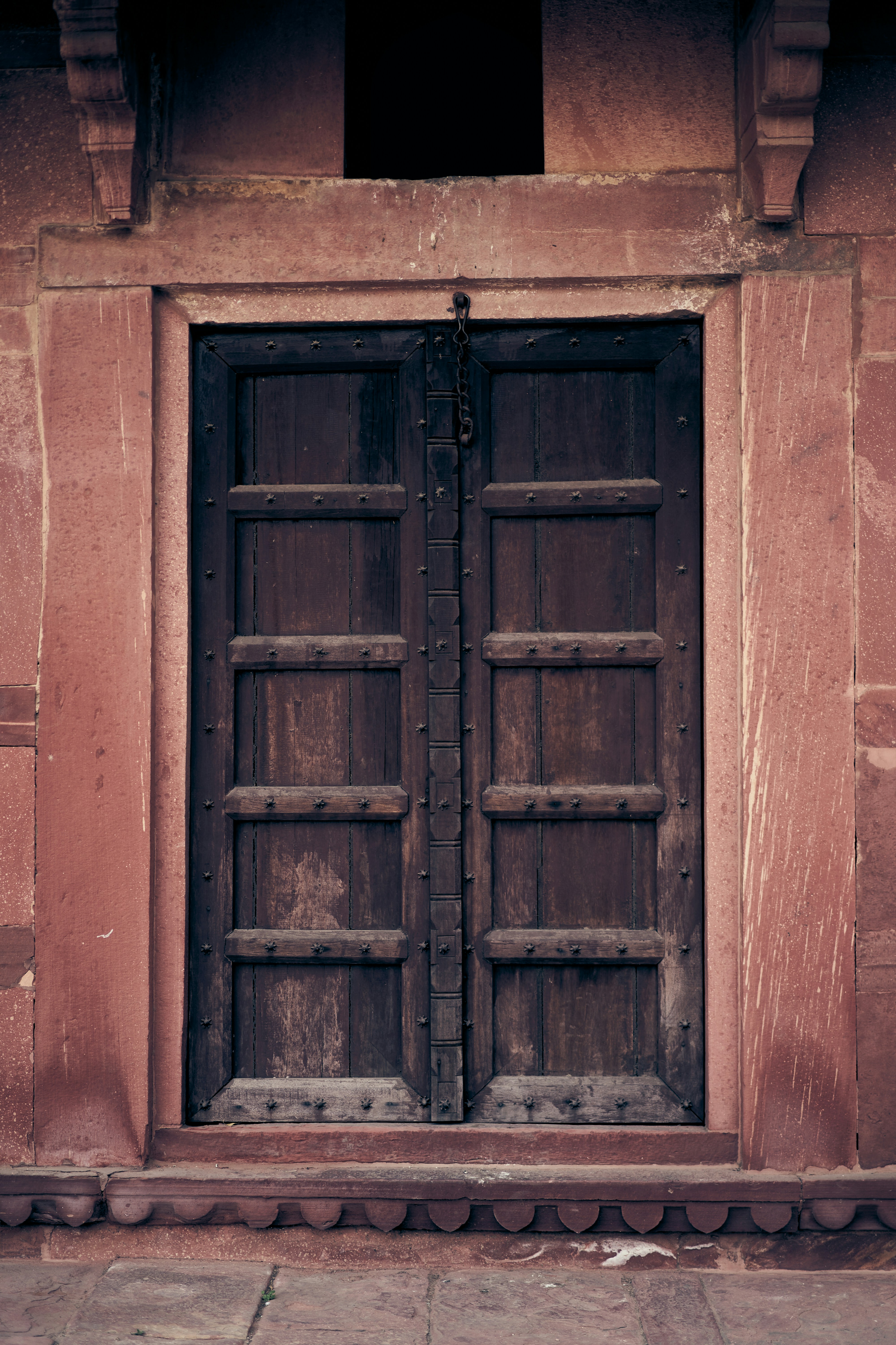 Iron Latch at Dusk: A Closed Door Framed by Red Stone
