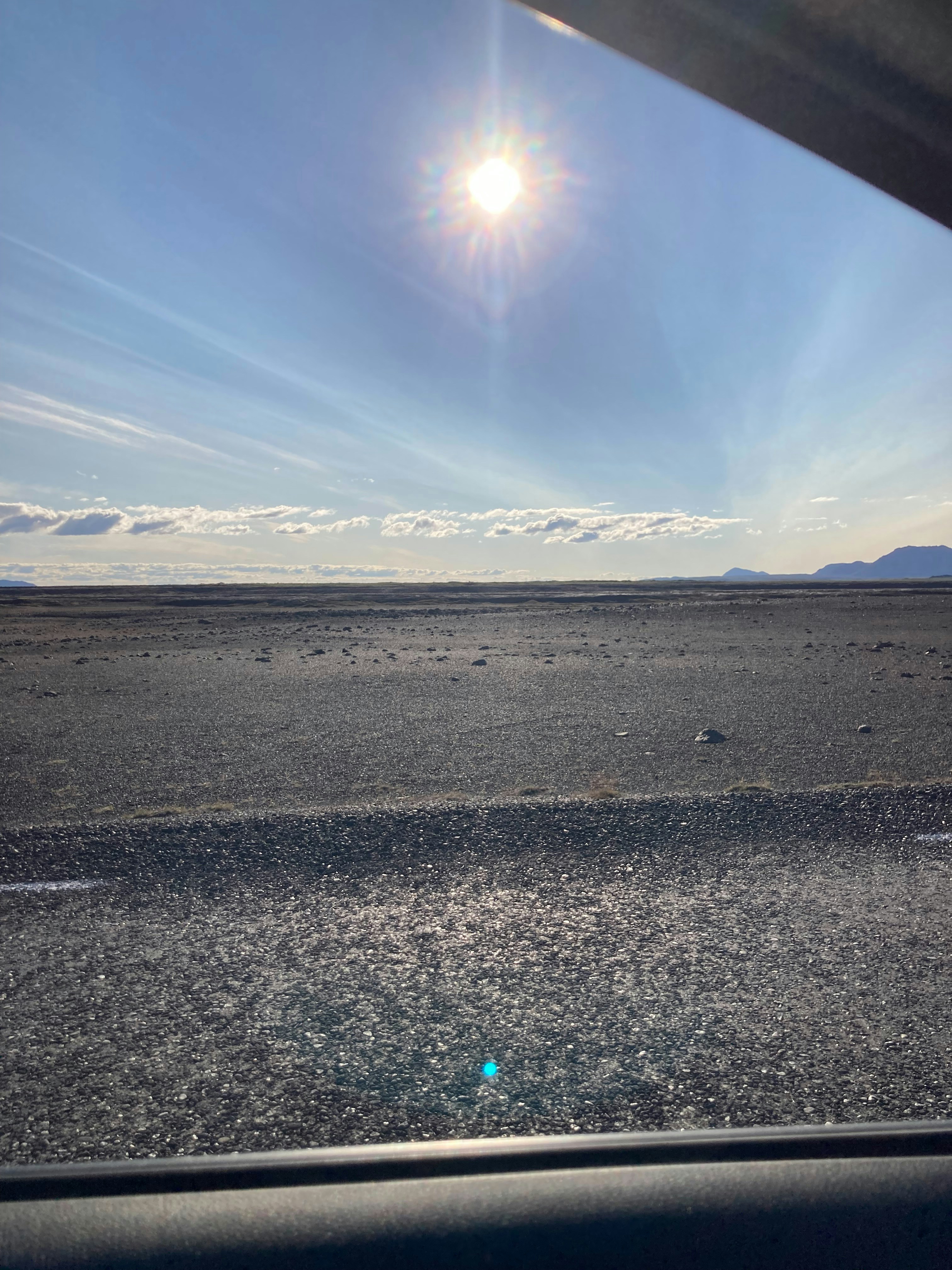 Sunlit Shoreline Through a Car Window