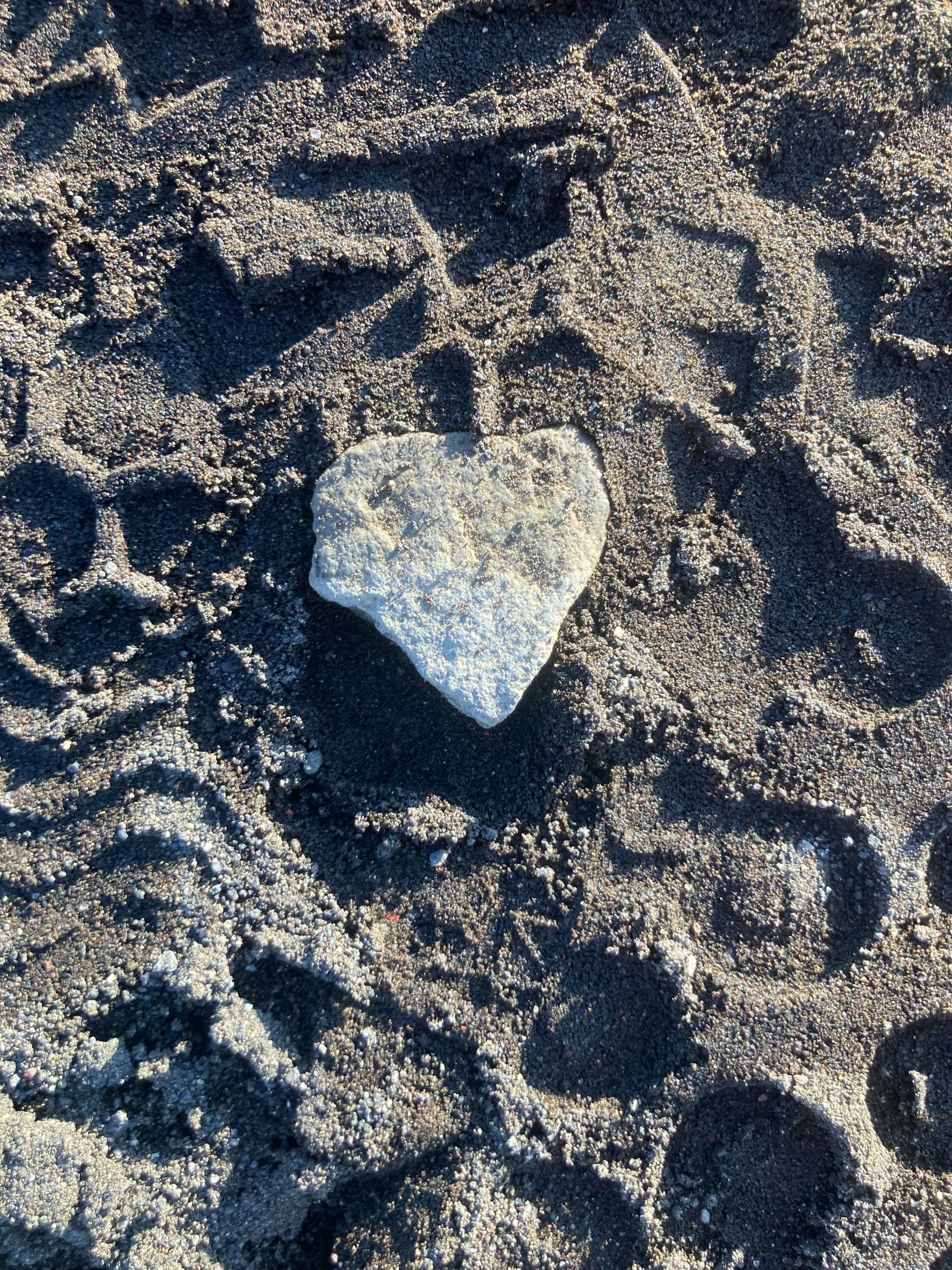Pebble Anchor in Sand: Centered Stone on a Patterned Beach Surface