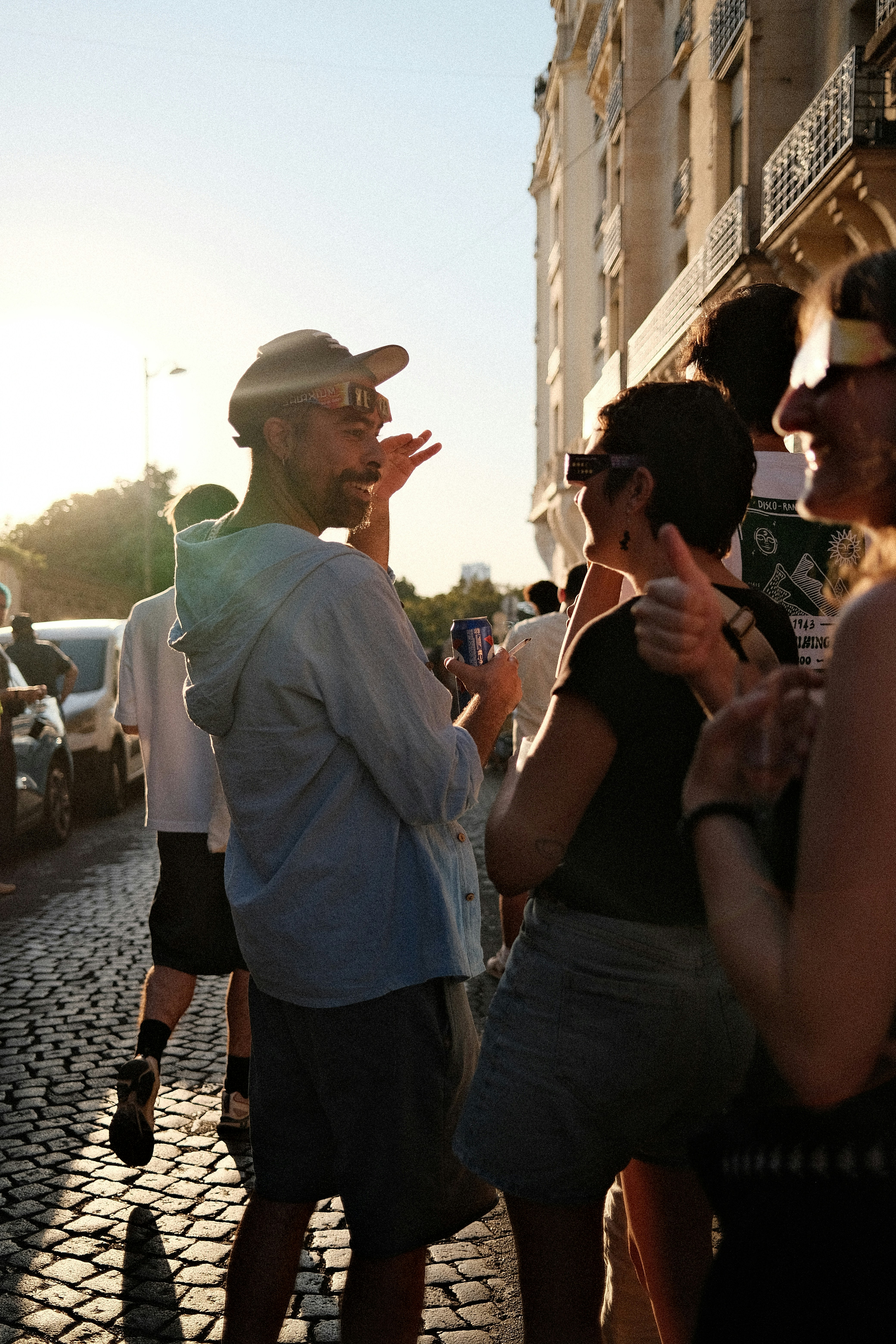 Sunlit Street Social: A Casual Moment in the Evening Crowd