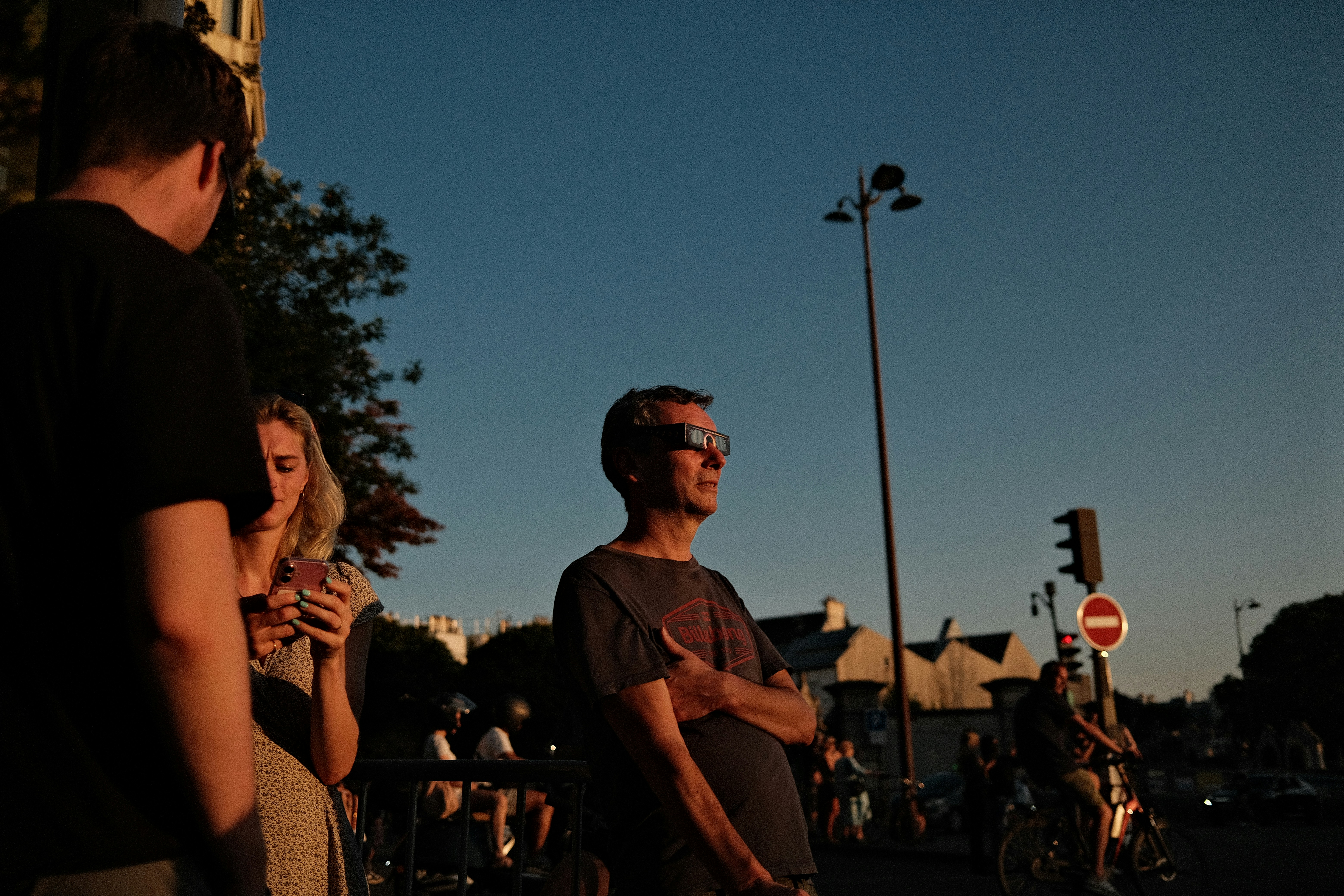 Sunlit Street Portrait: A Moment of Quiet Amid Evening Strolls